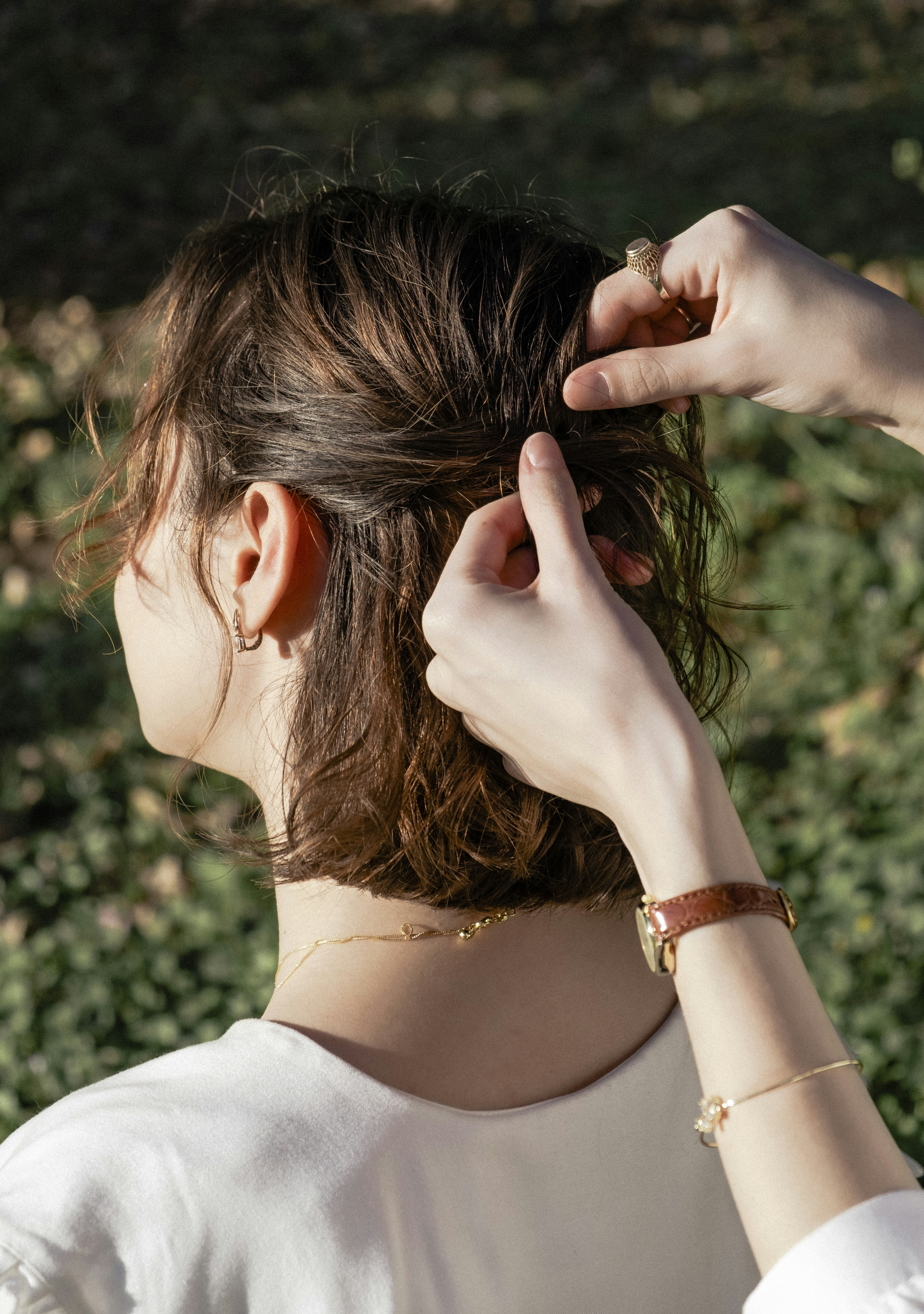 Sunlit Nape: A Quiet Hair-Tuck Moment in the Park