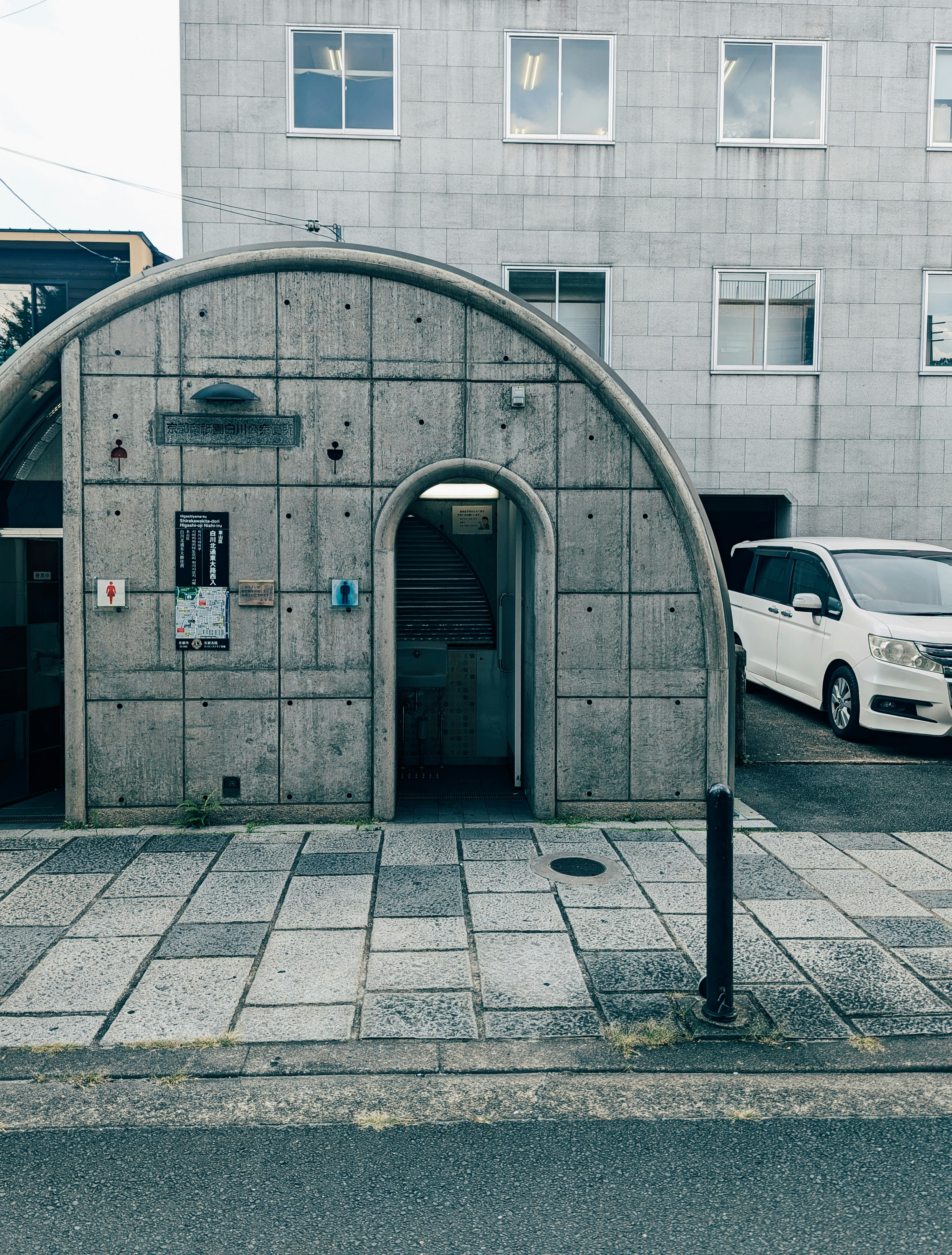Arc of Entry: A Concrete Portal Framed by a Modern Facade