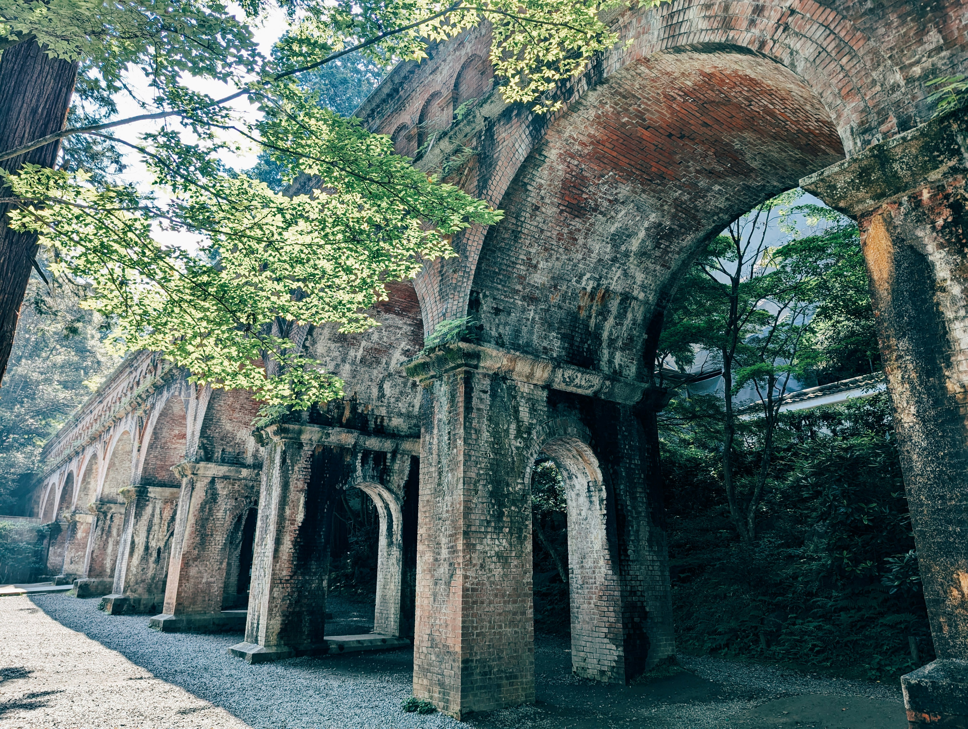An old building with a stone arch in the middle of it photo – Free ...