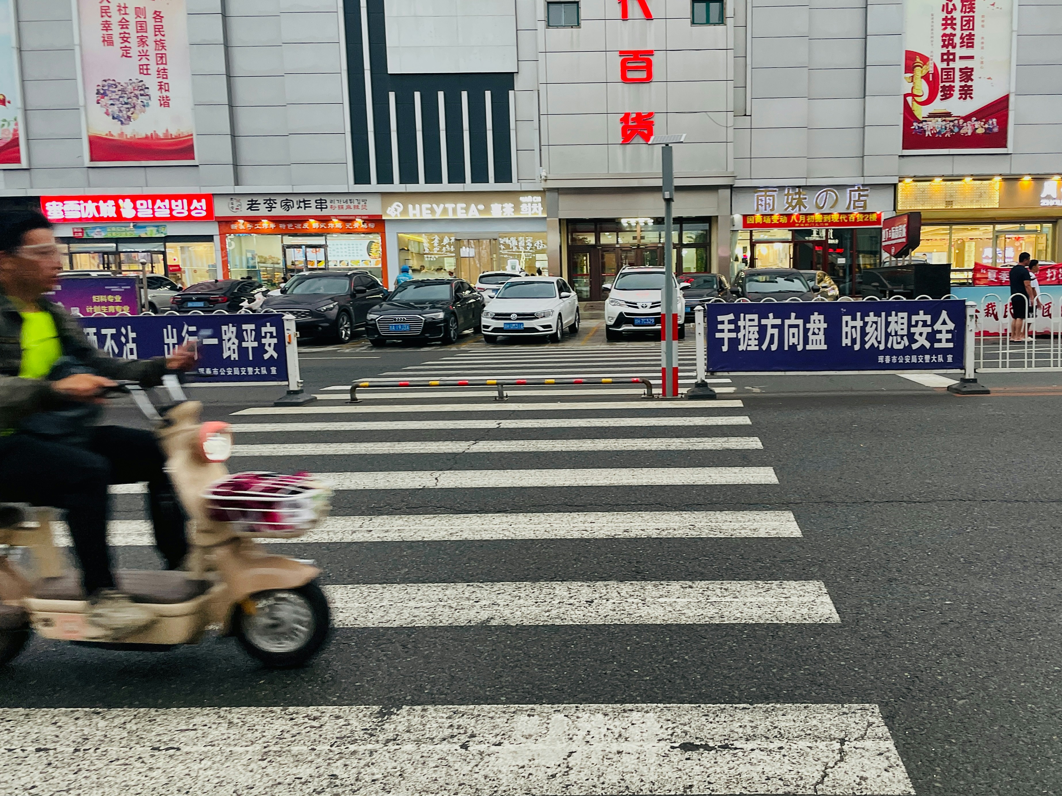 A man riding a scooter across a street photo – Free China Image on Unsplash