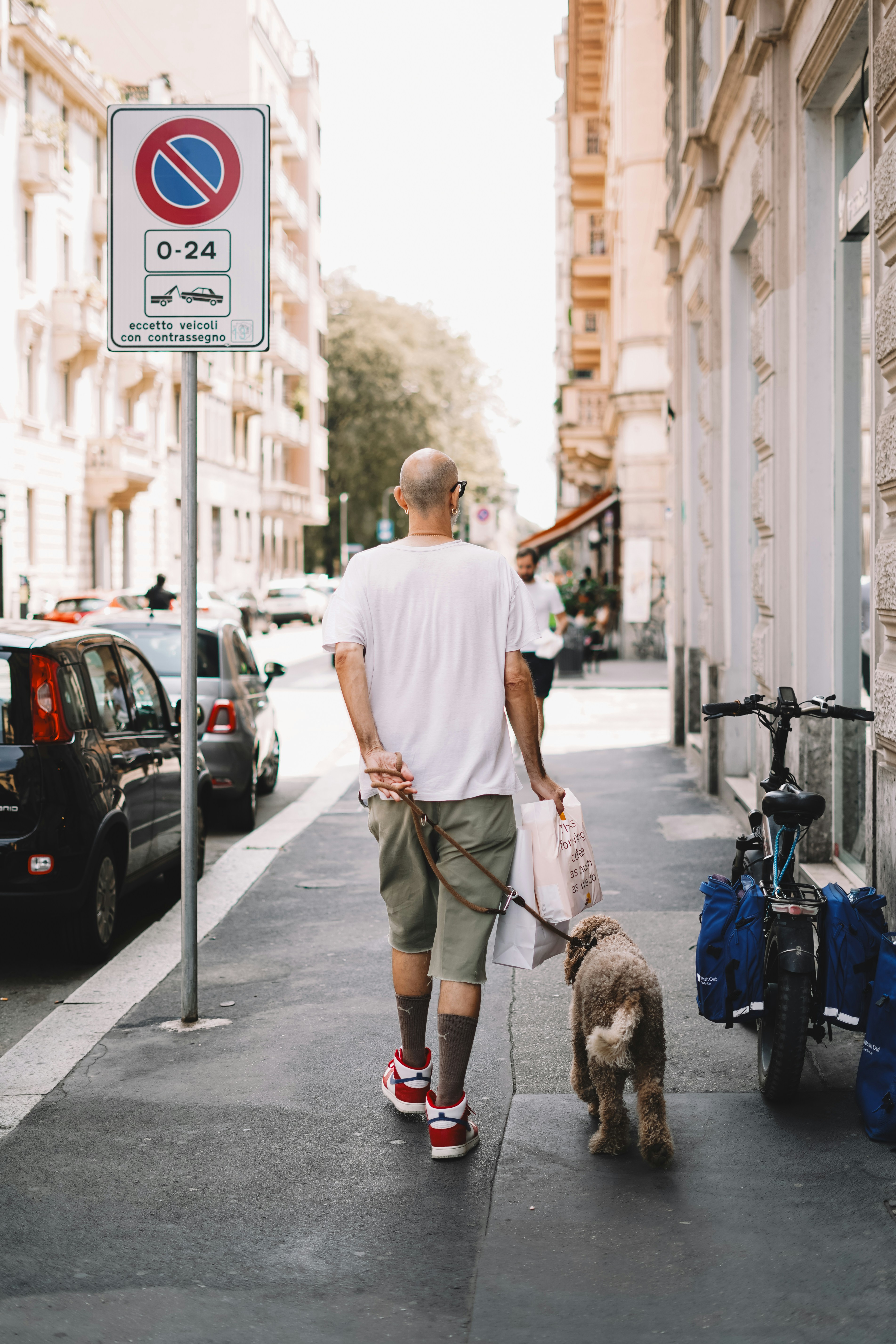 A man walking his dog down the street photo – Free Street photography ...