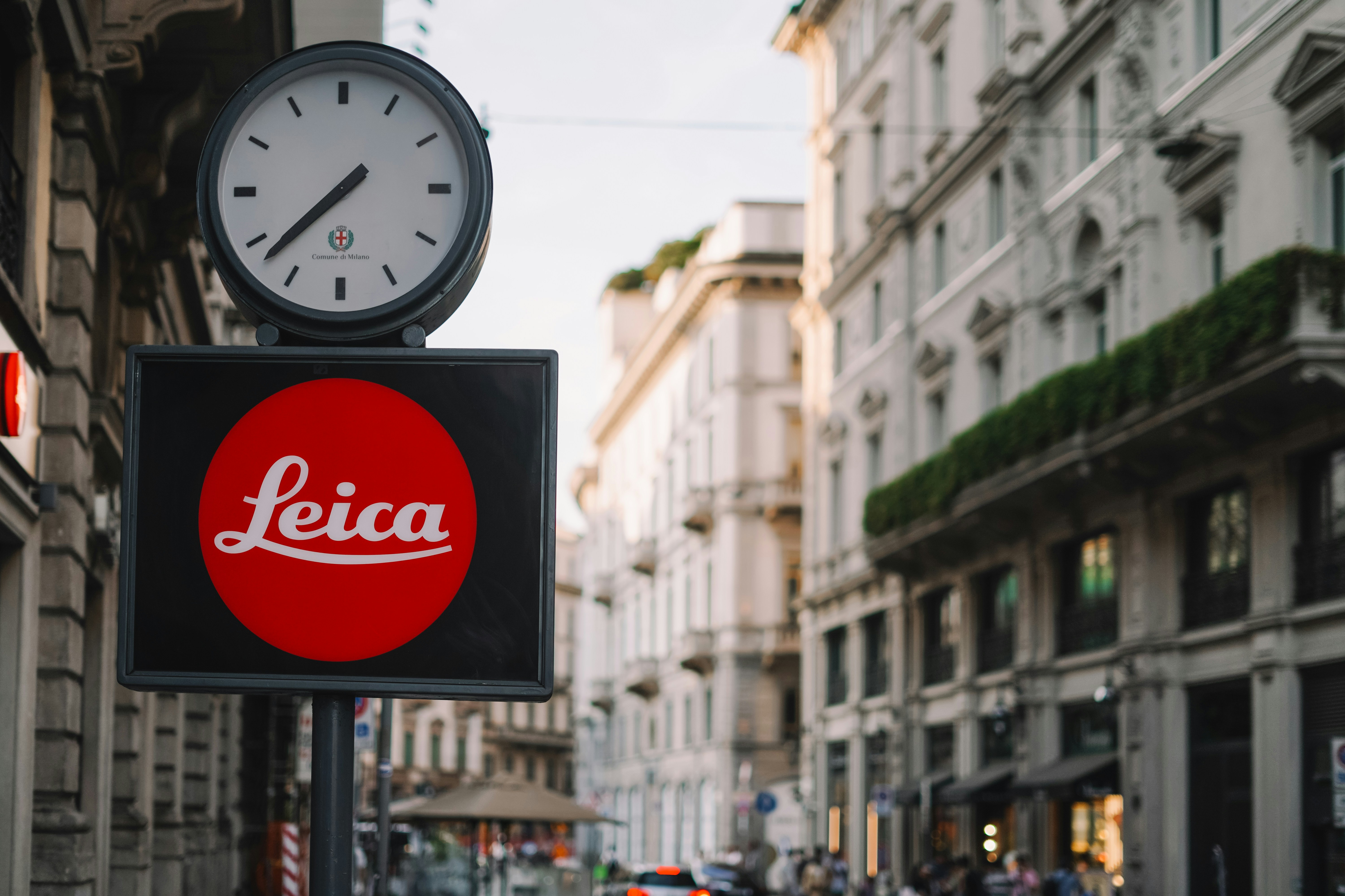 A clock on a pole on a city street photo – Free Italy Image on Unsplash