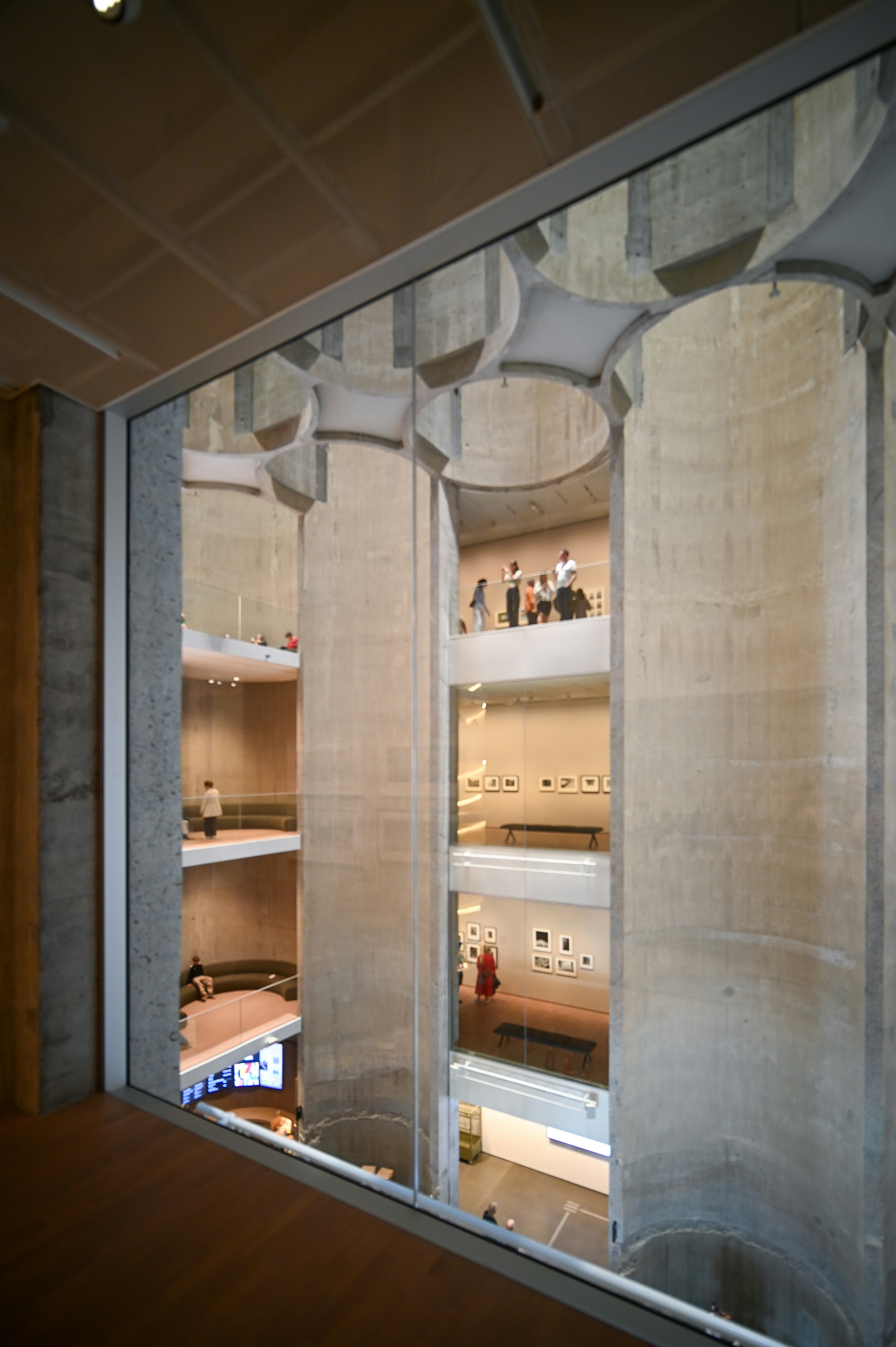 Brutalist Lightwell: Visitors Navigate a Multilevel Concrete Atrium