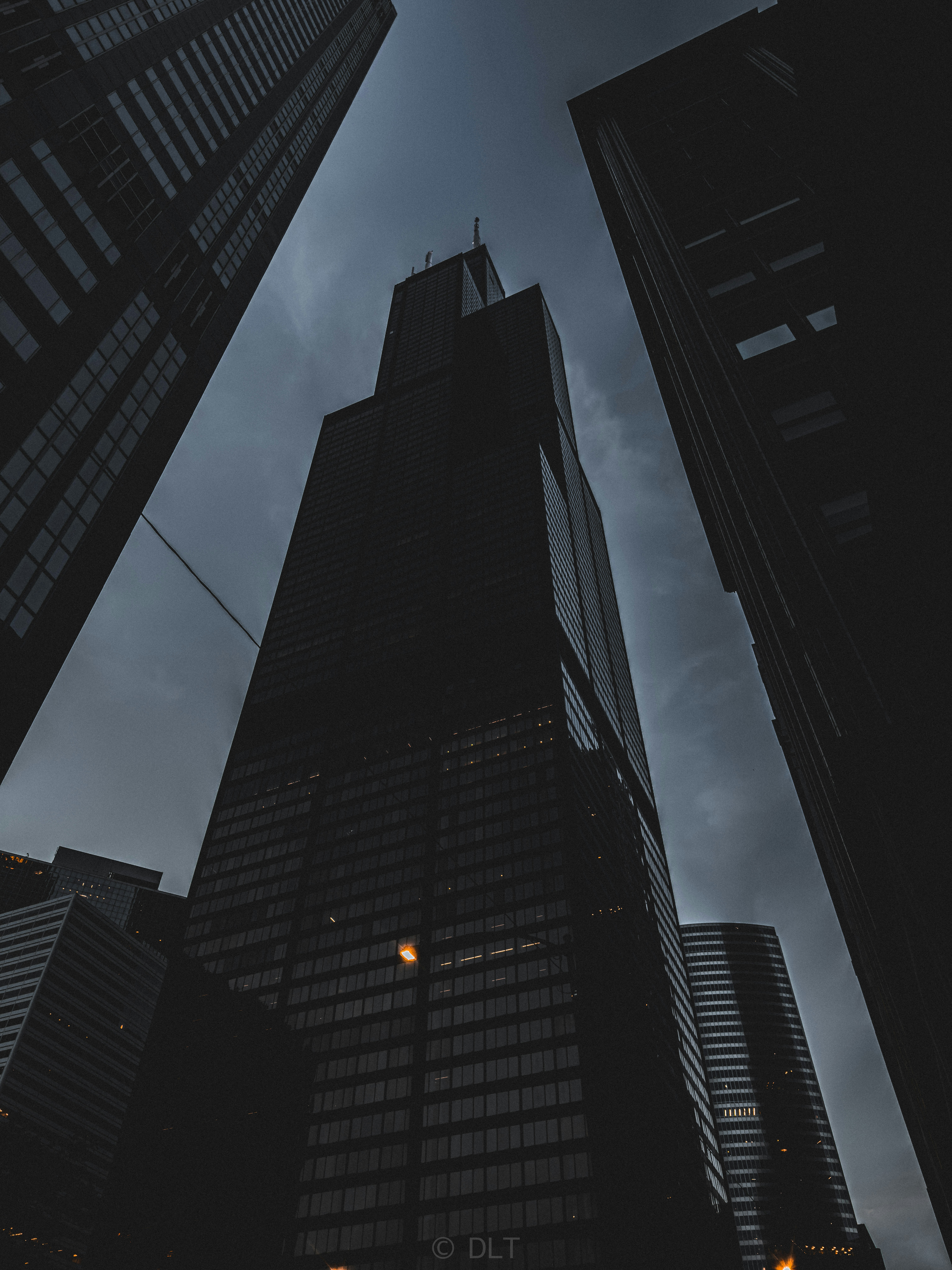 A tall building towering over a city filled with tall buildings photo ...