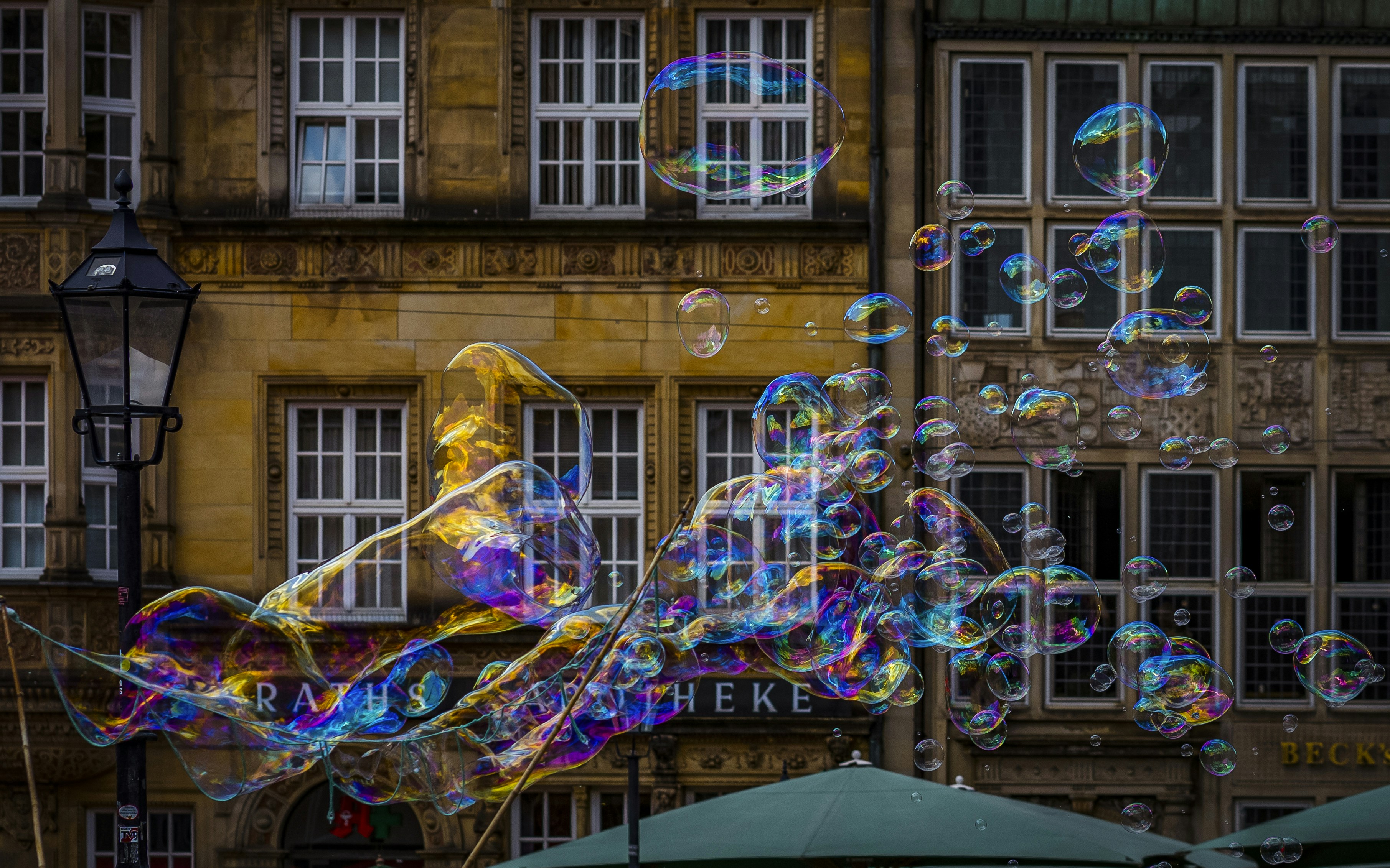 A large group of bubbles floating in front of a building