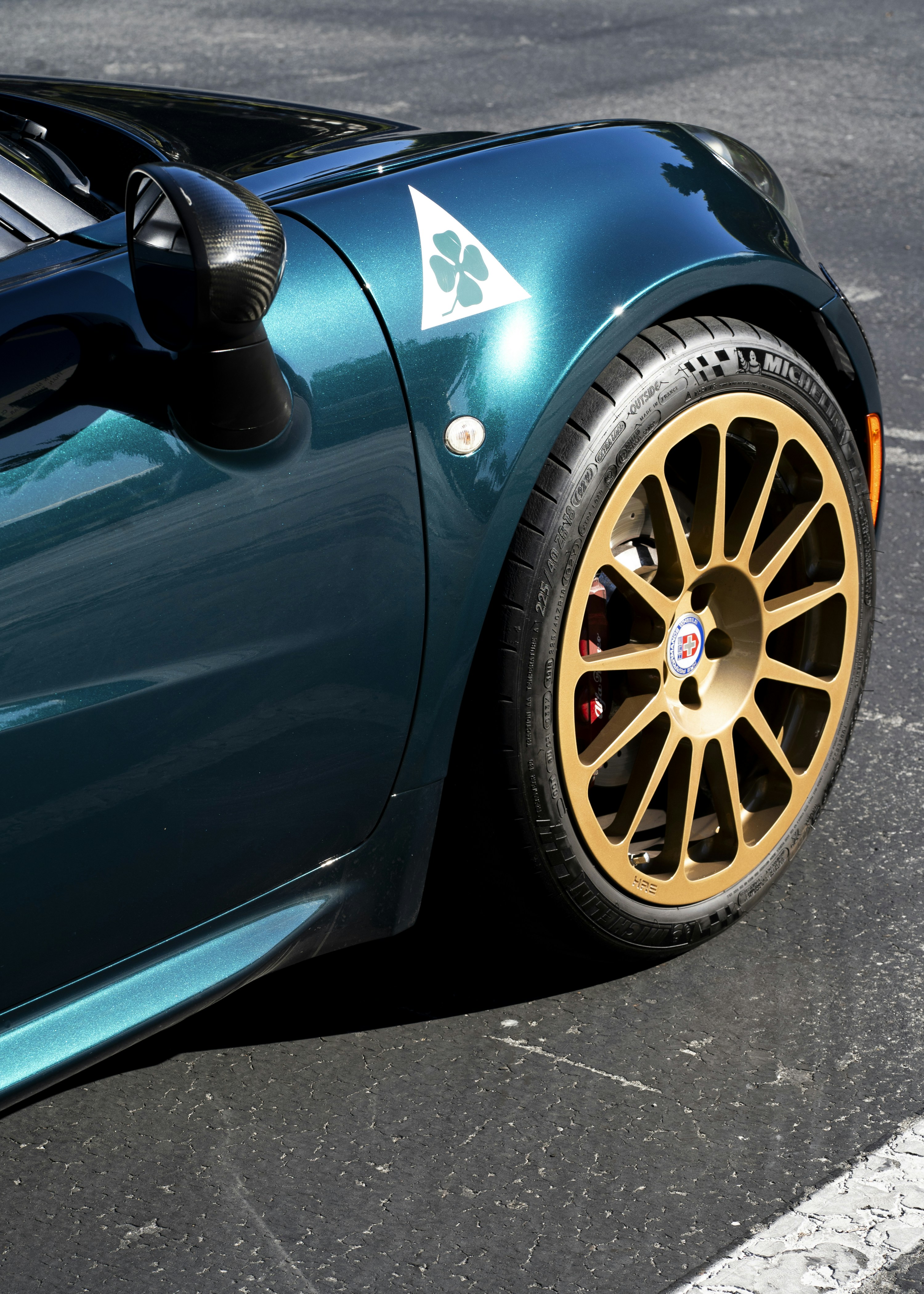 Teal Velocity: Gold Alloy Wheel on a Glossy Teal Sports Car