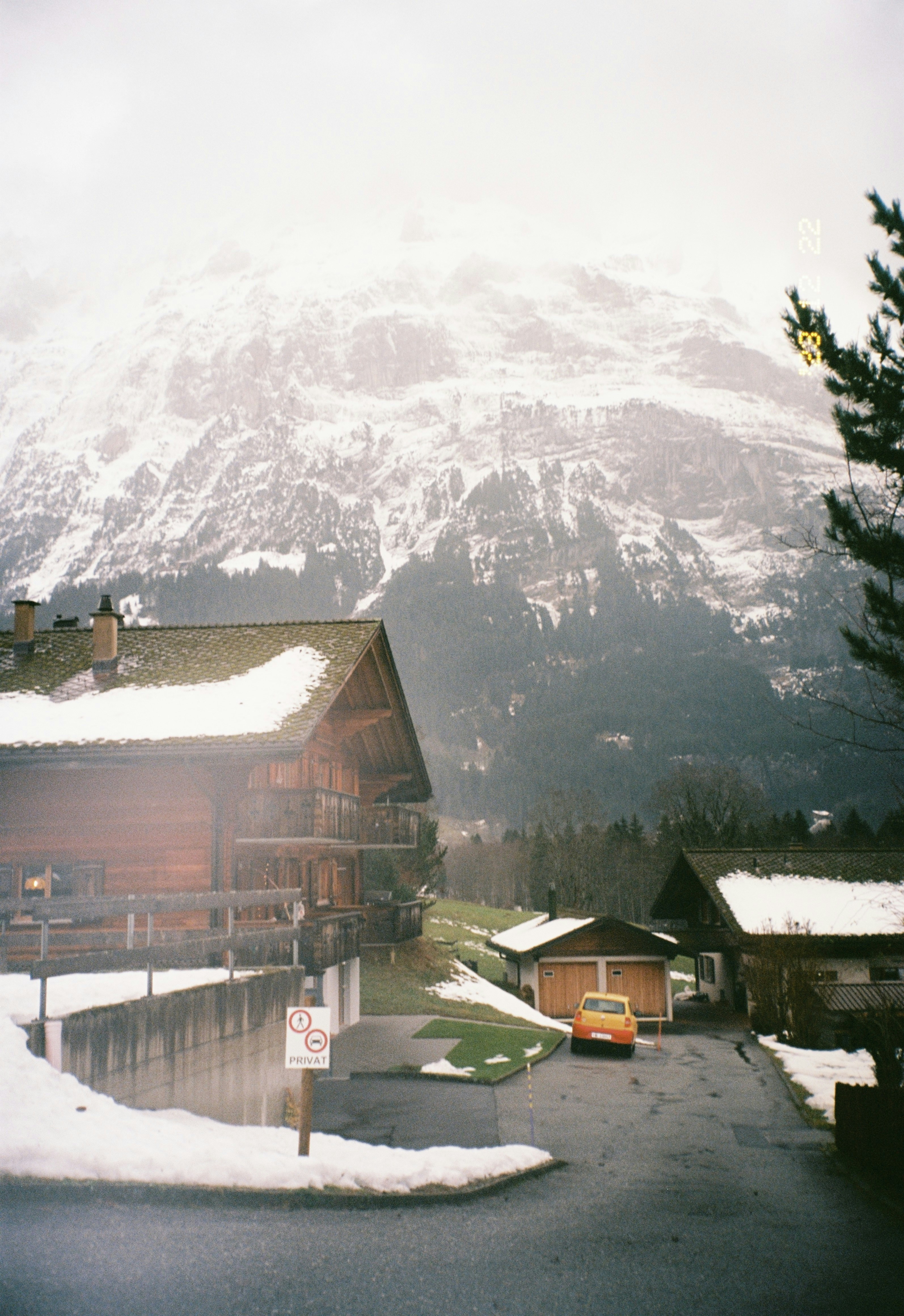Snowy chalet village beneath a towering alpine rim