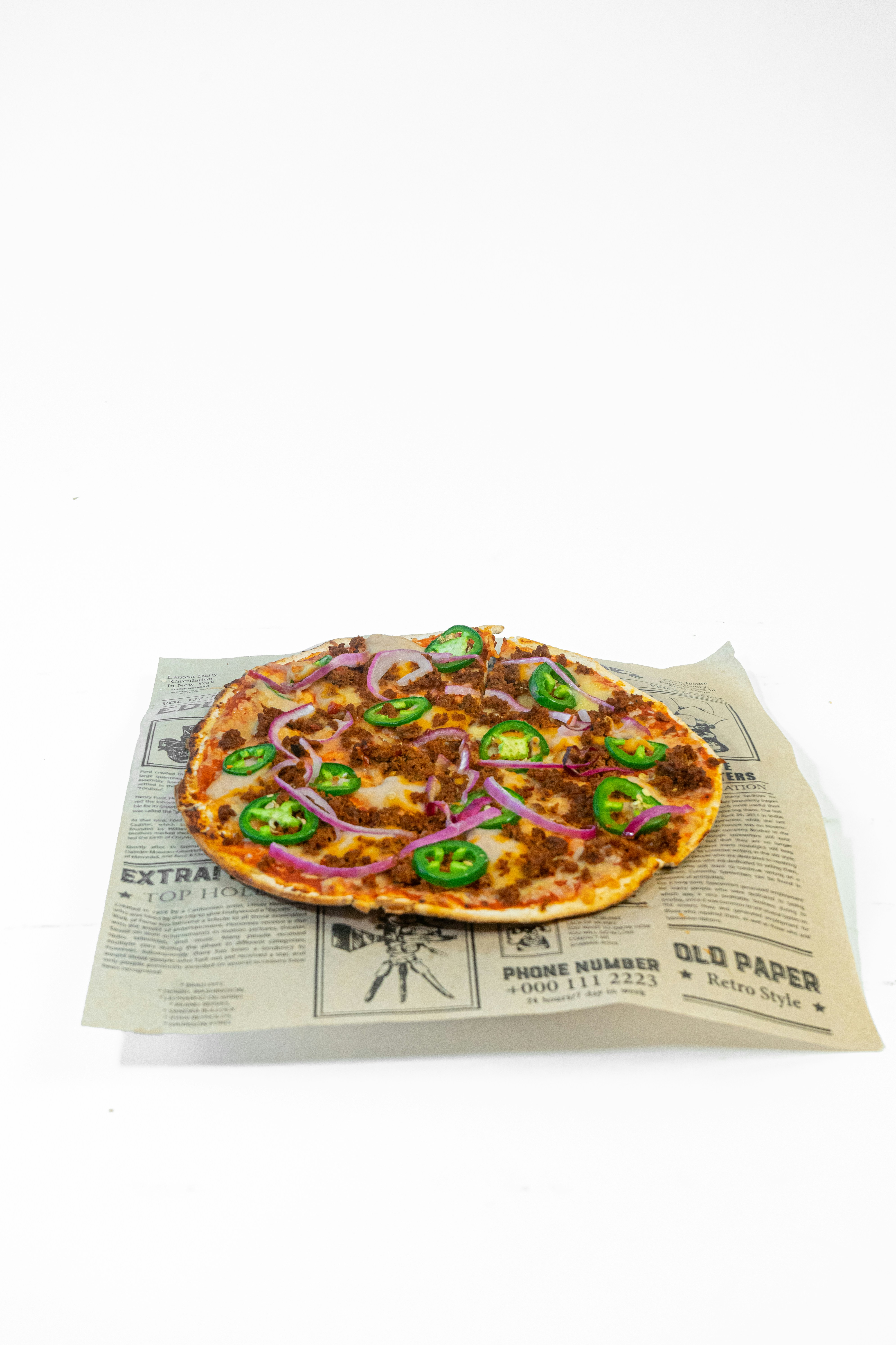 Una pequeña pizza encima de un periódico foto – Imagen de Comida ...