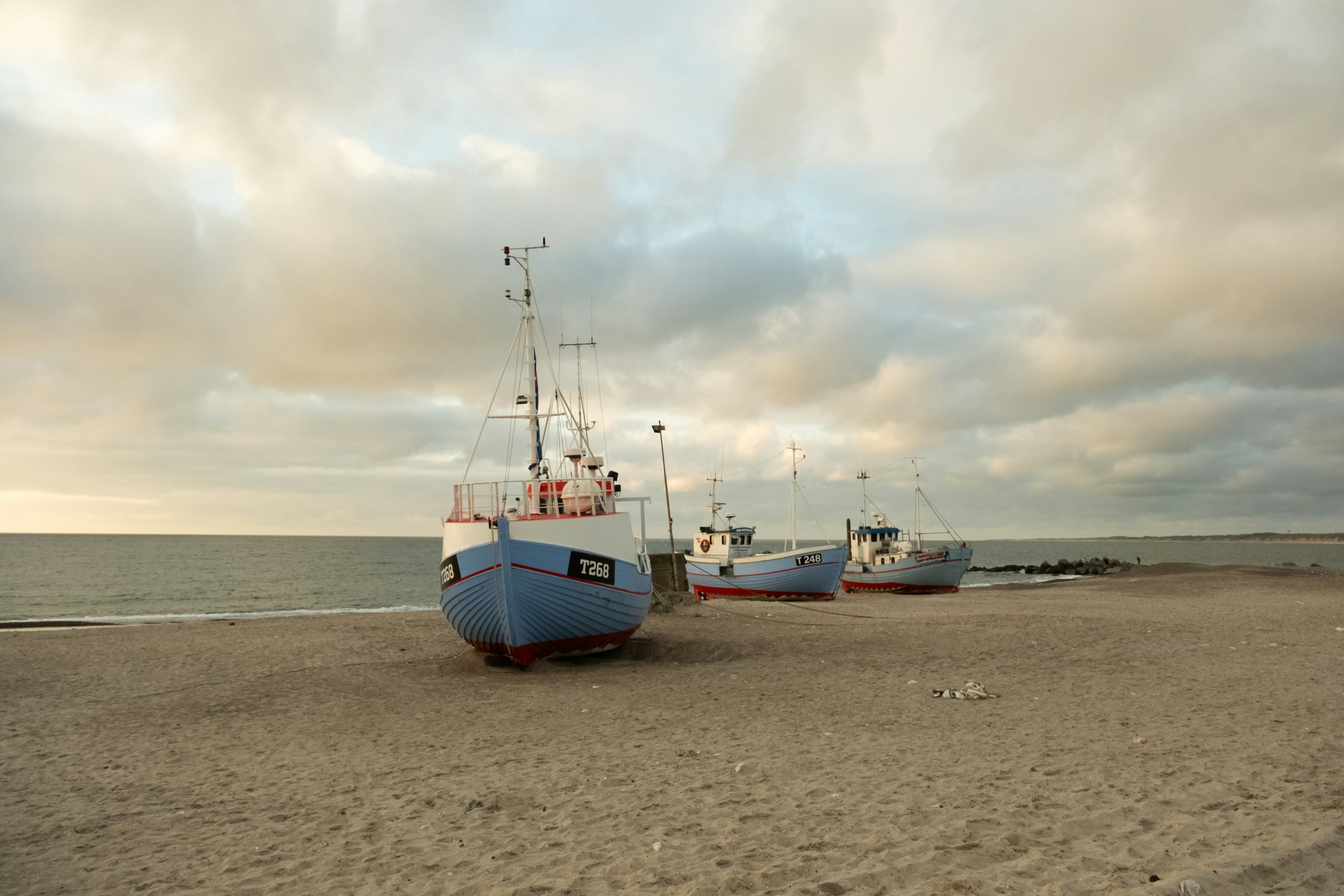 Blue Boats Rest on Wind-Washed Beach