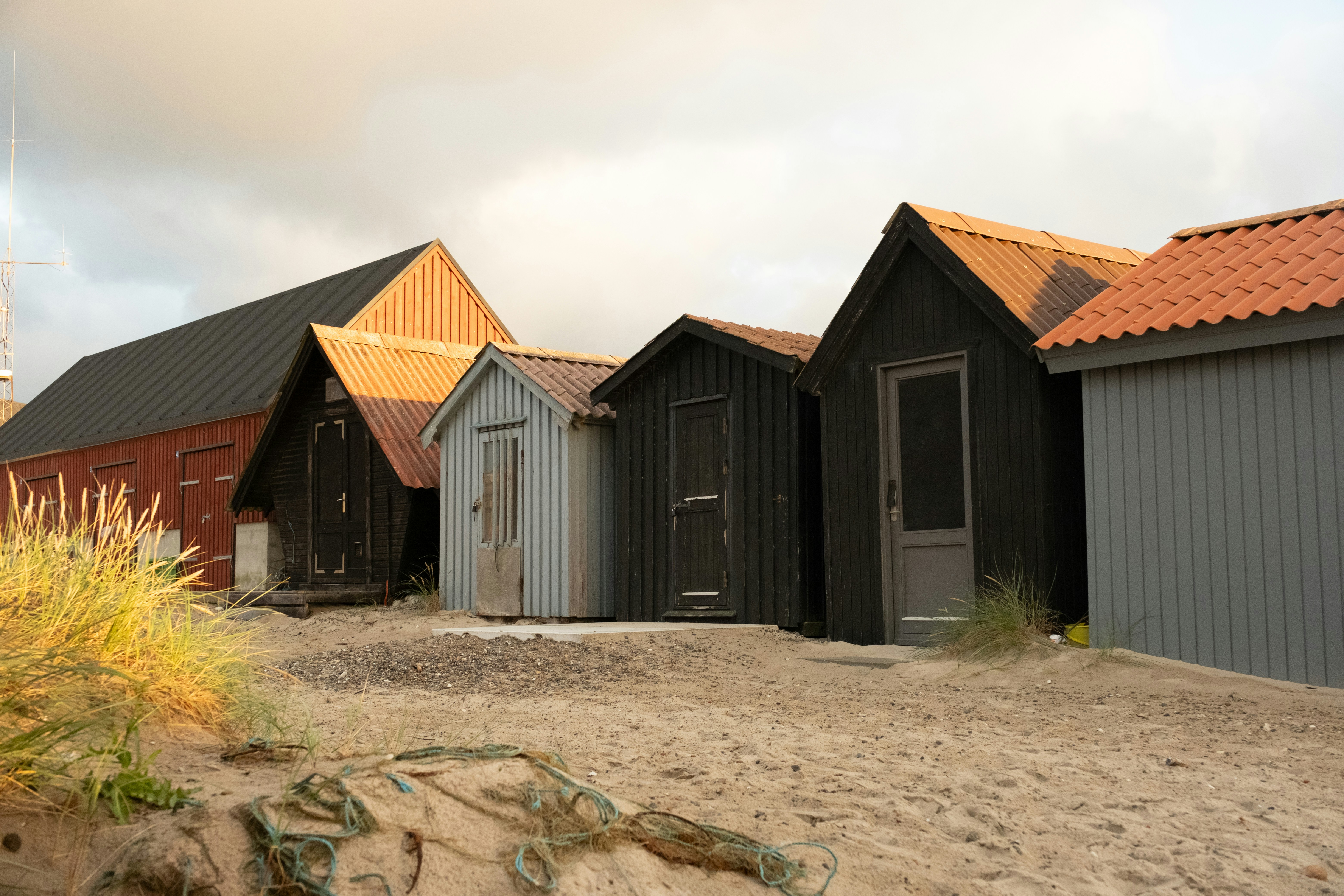 A row of beach huts sitting on top of a sandy beach photo – Free Beach ...