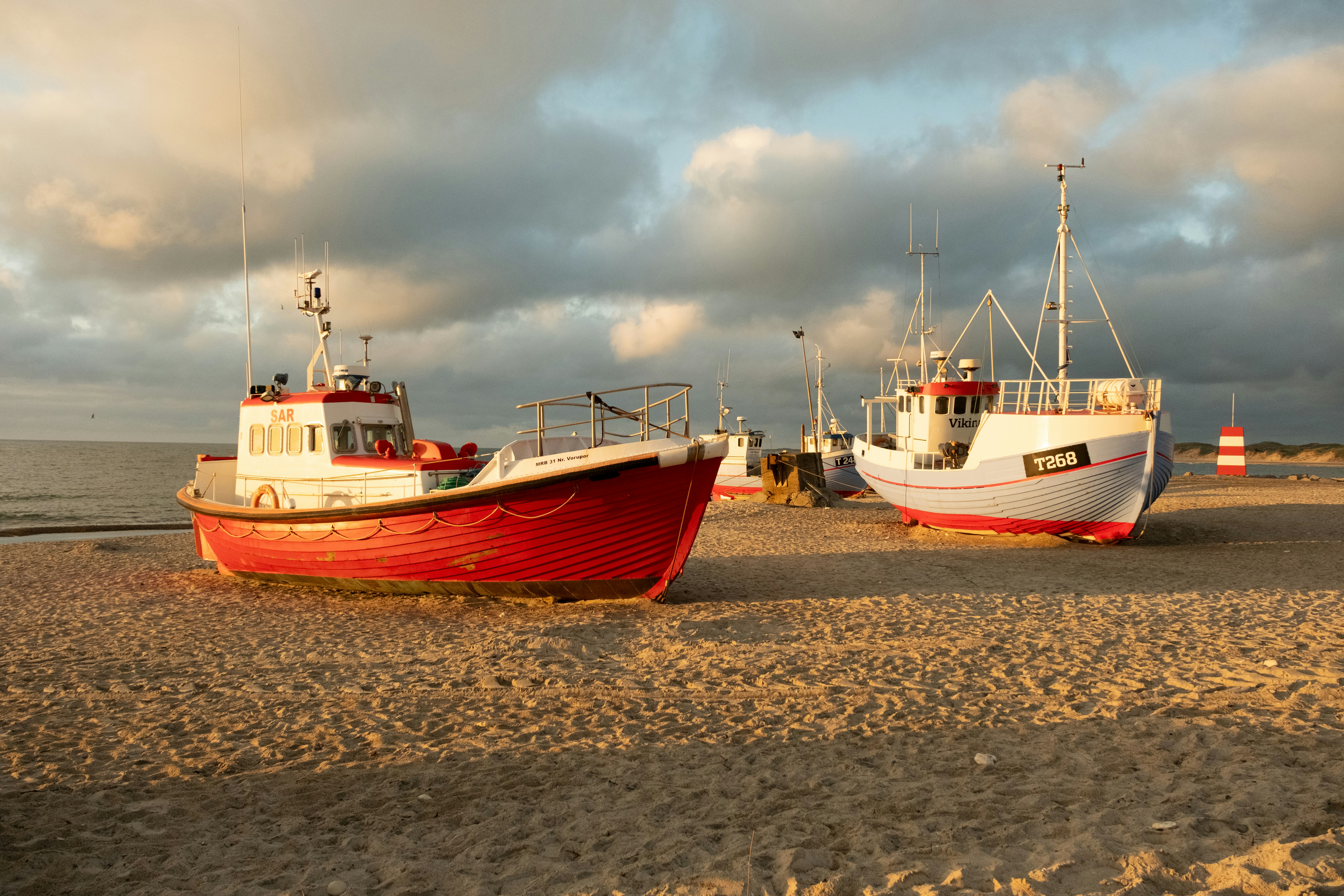 Un par de botes sentados en la cima de una playa de arena foto – Imagen ...