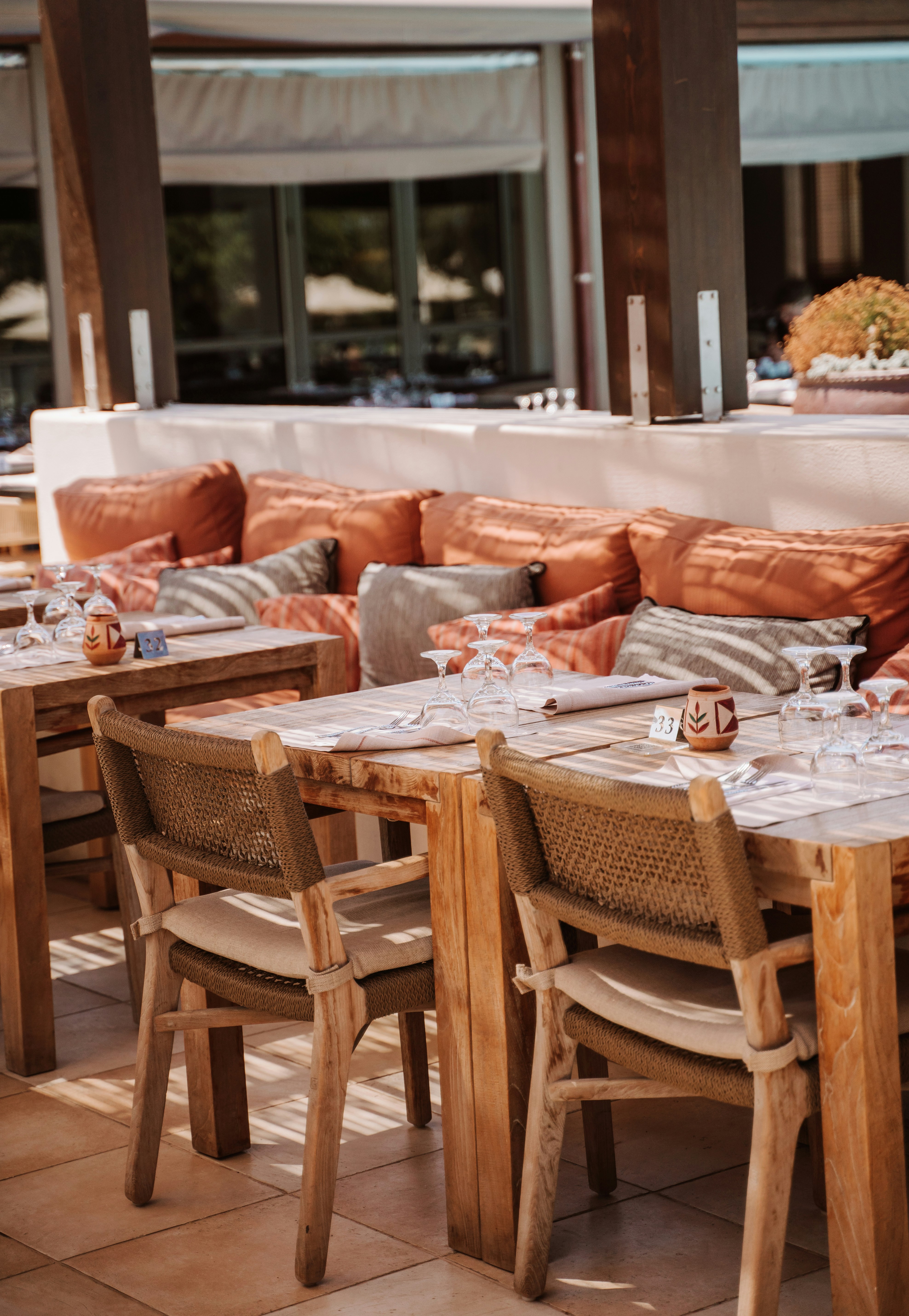 A restaurant with tables and chairs and a table with place settings ...