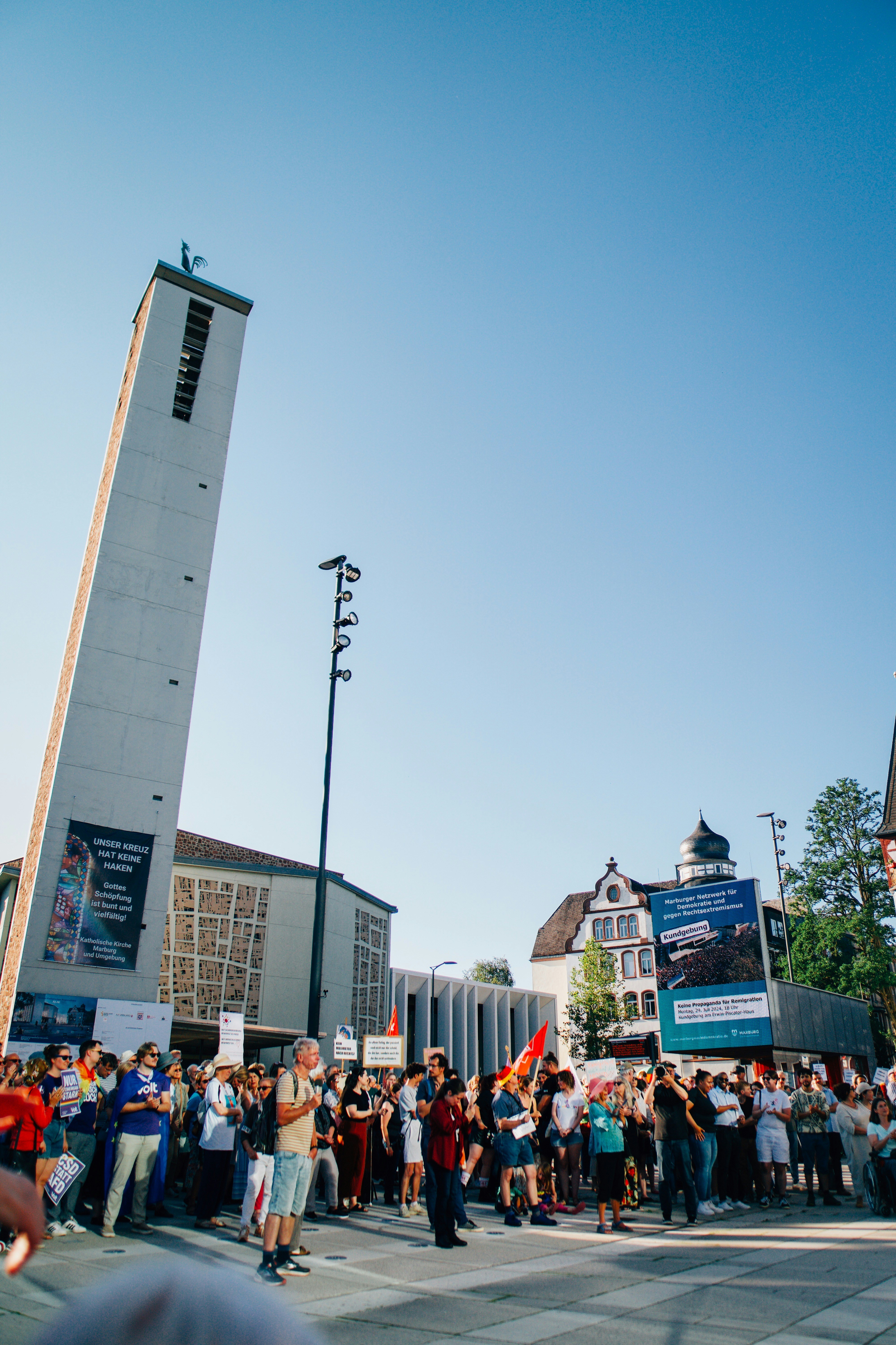 A crowd of people standing around a tall building photo – Free Marburg ...