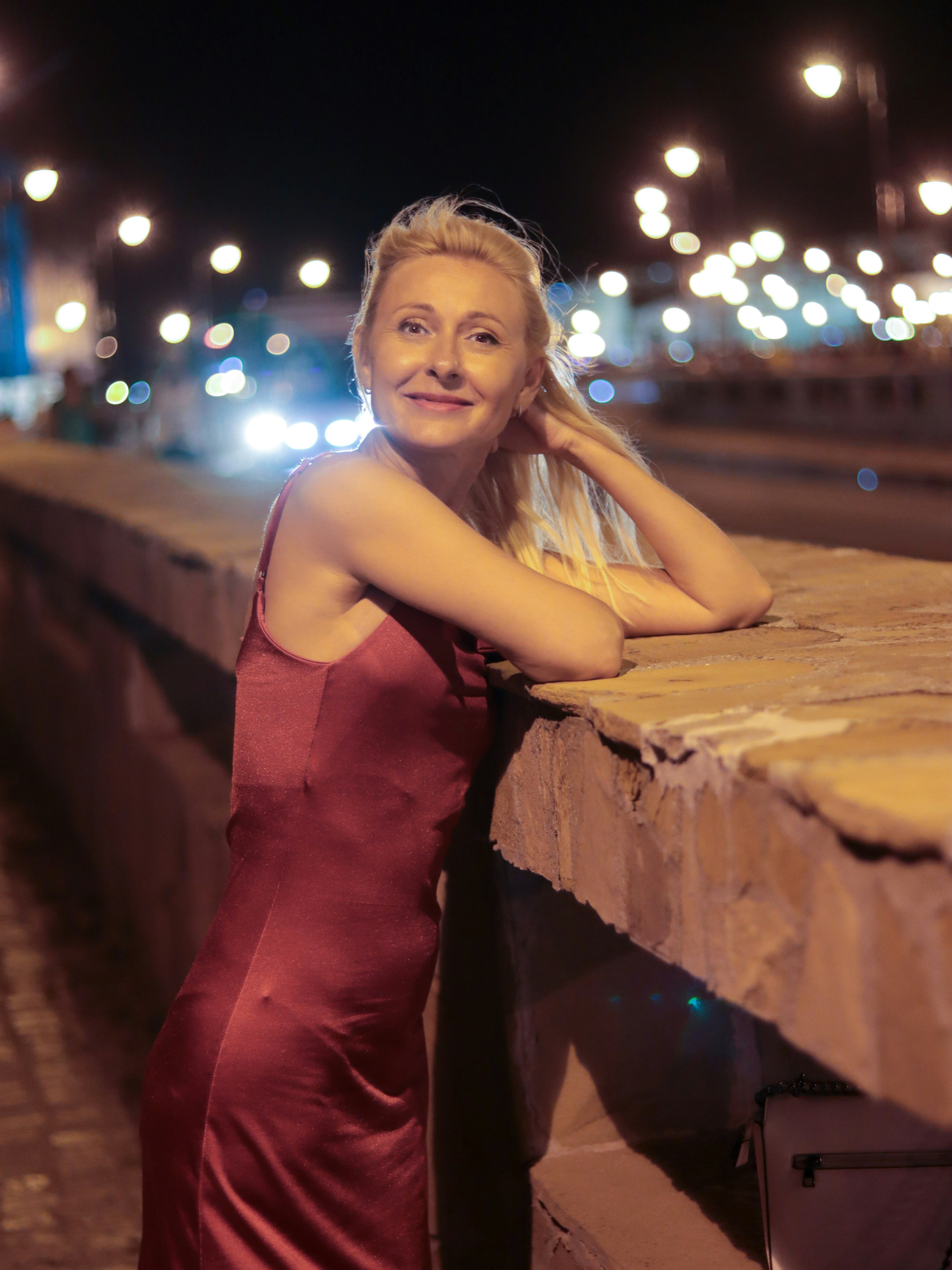 Warm Night Portrait on a City Railing: burgundy dress against a soft city glow