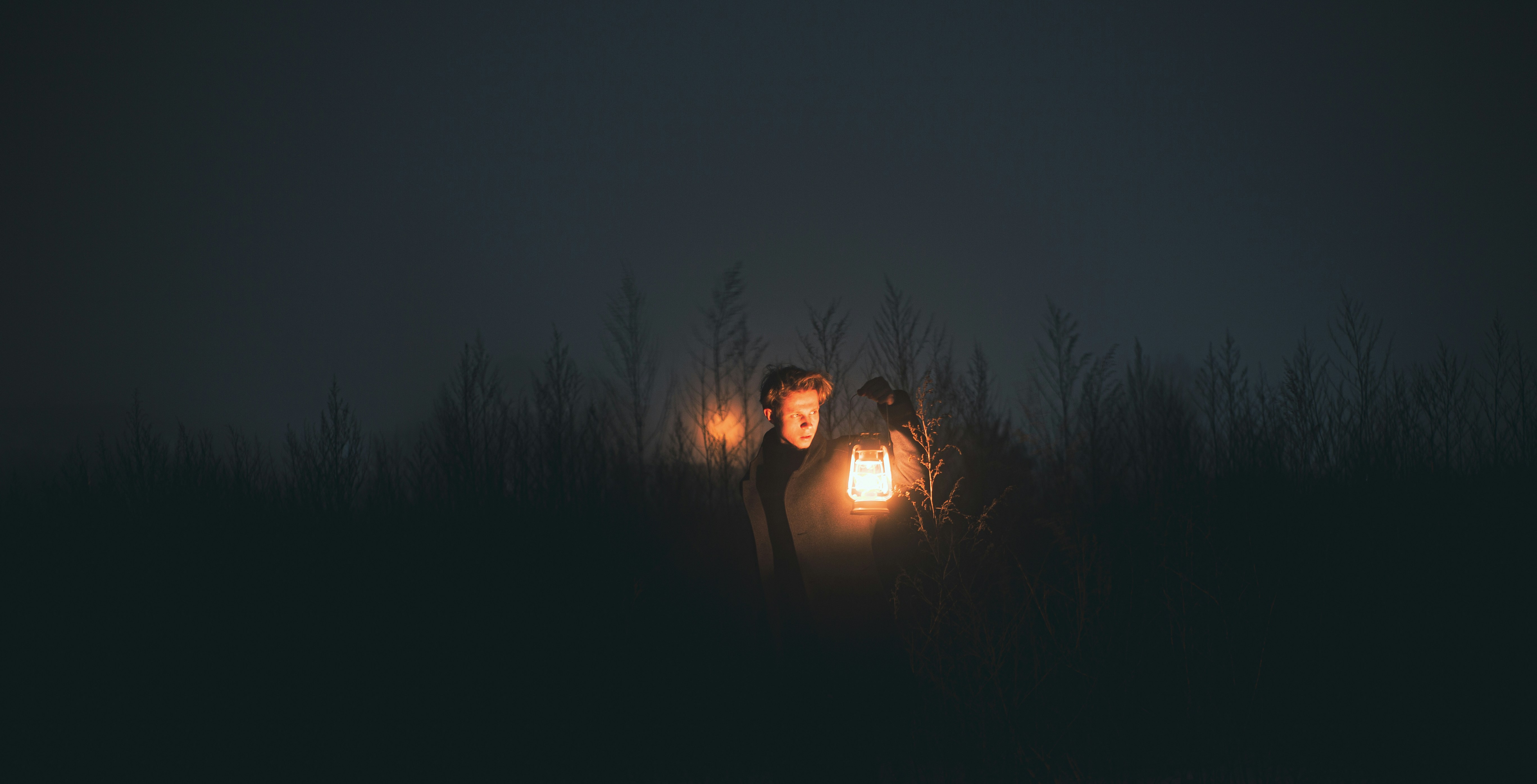 Lantern-Borne Quiet: A Lone Figure in a Night-Grass Field