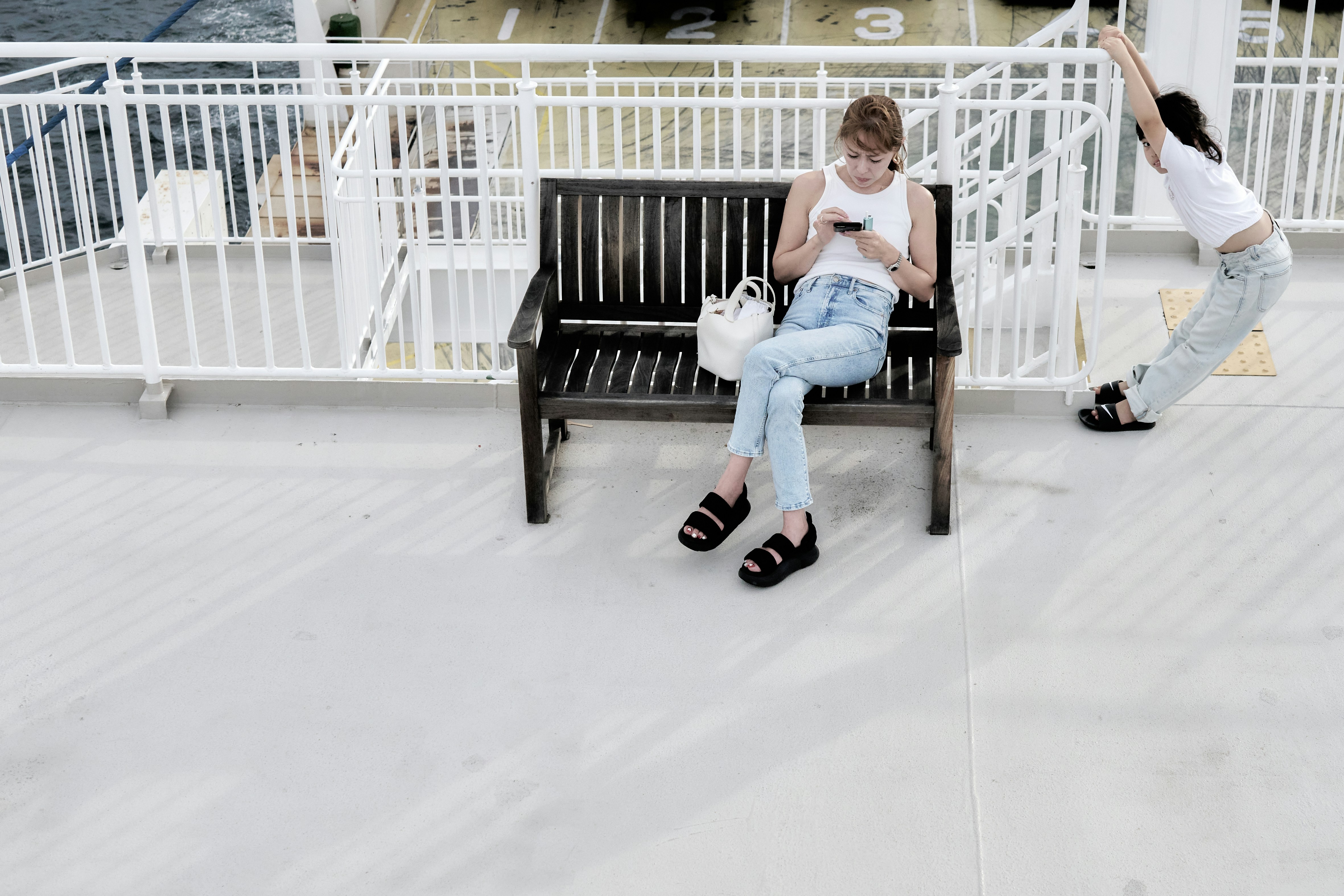 Sunlit Rooftop Pause: A Woman on a Bench in Quiet Focus