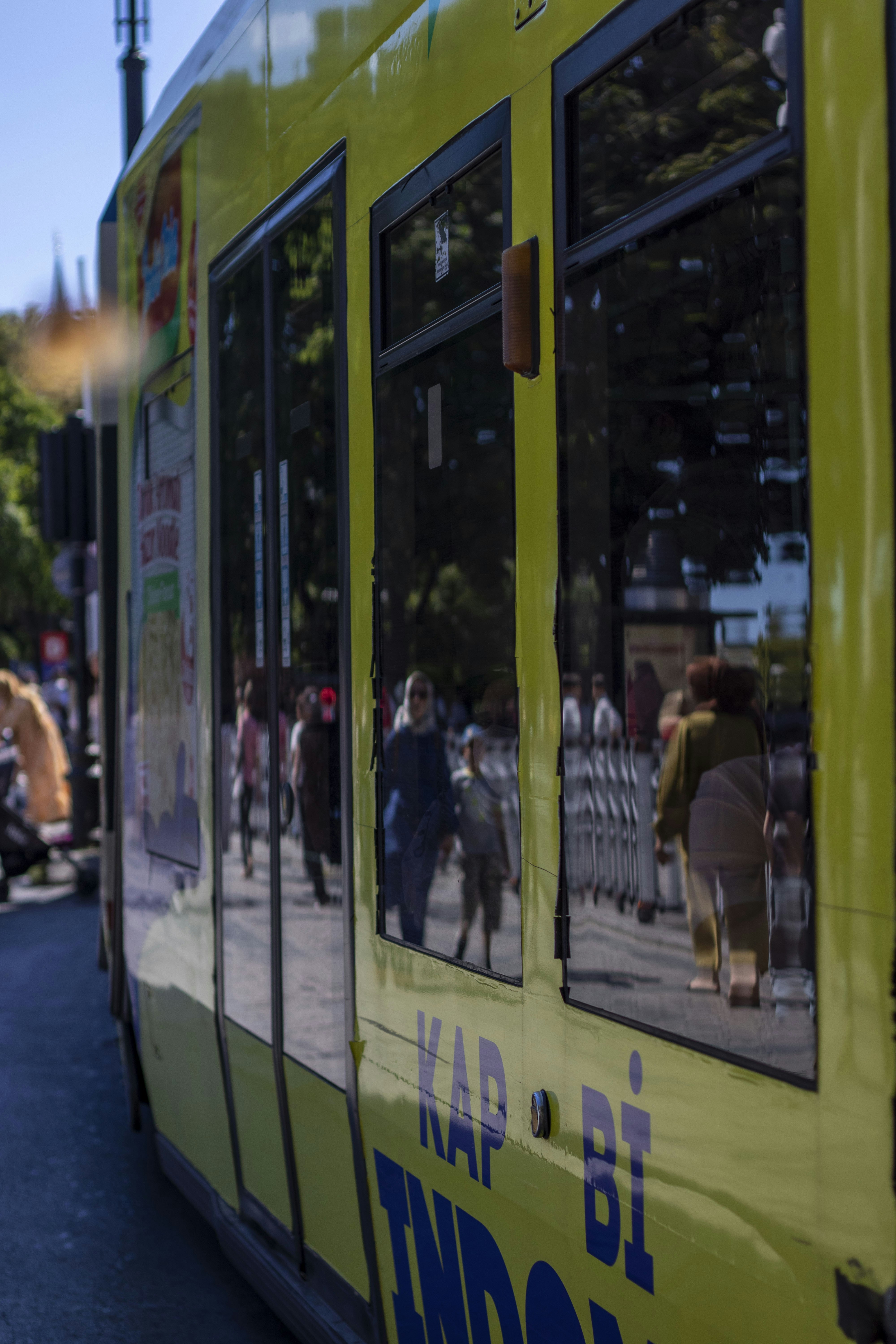 Yellow tramfront Reflections: People and Glass on a City Street