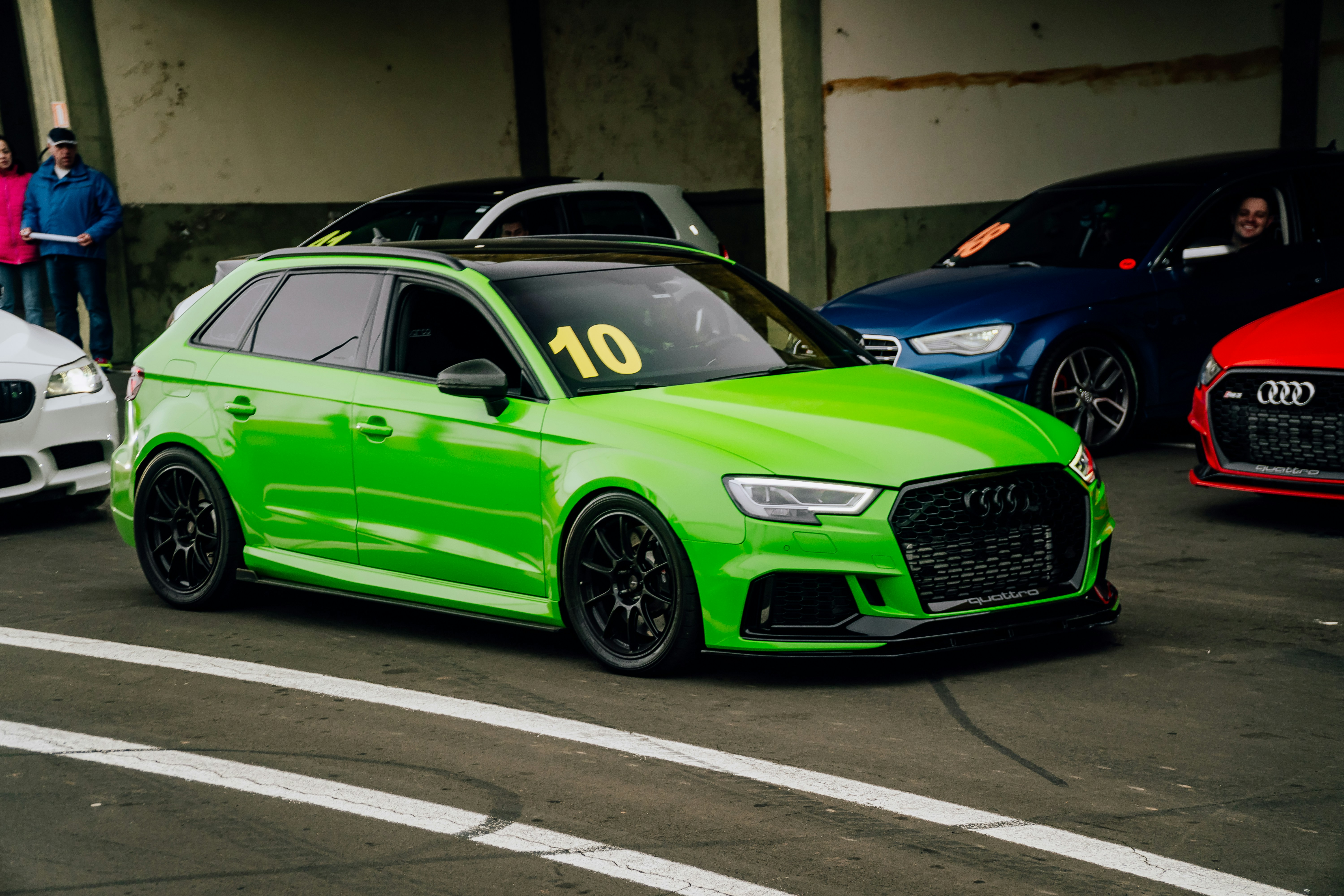 A green car driving down a street next to other cars photo – Free Pic ...