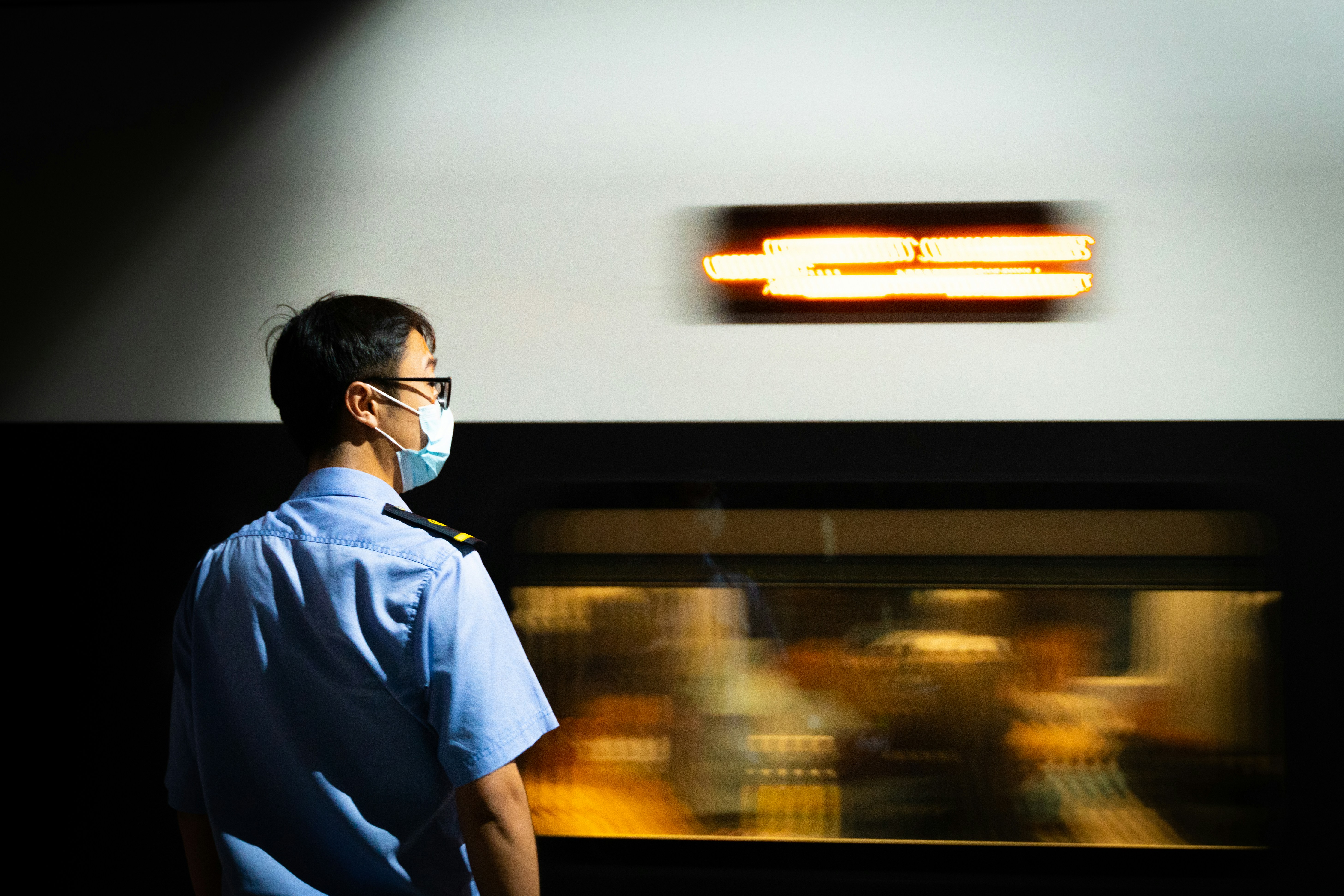 Blue Uniform, Blurred Rails: A Moment of Stillness in Motion