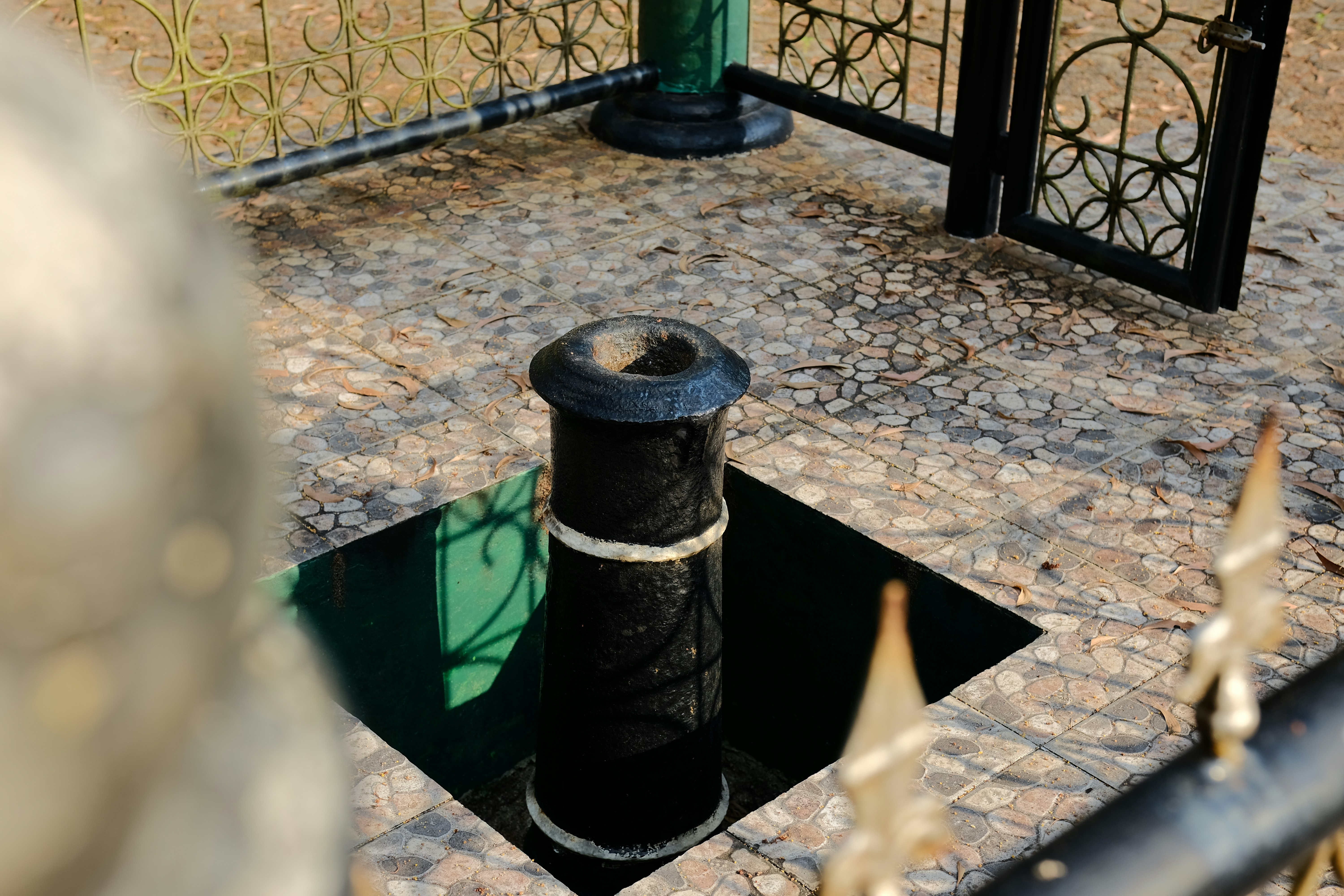 The Quiet Pillar: A Black Cylinder Guarding a Mosaic Courtyard
