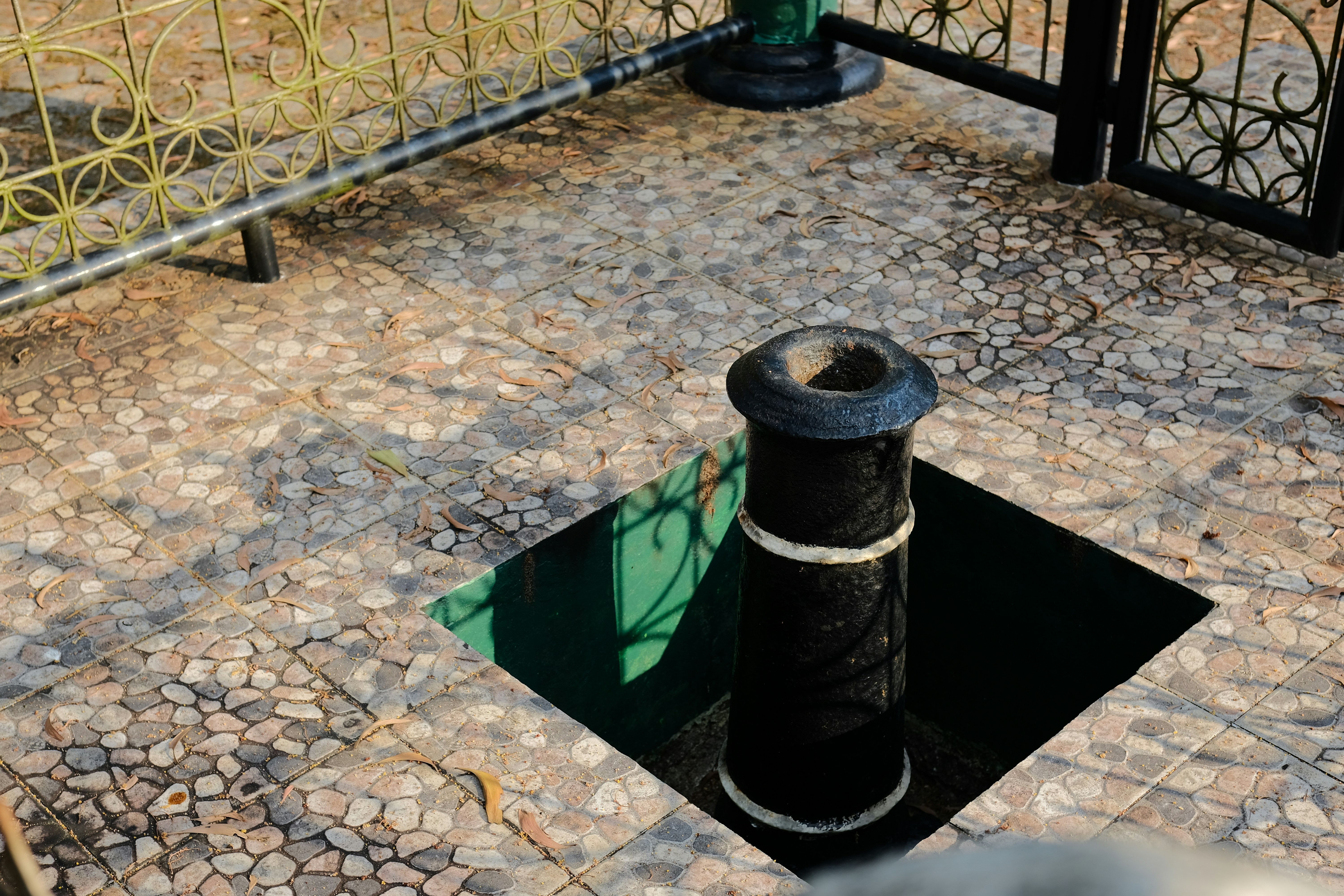 The Quiet Well: A Pebble Courtyard's Dark Cylinder
