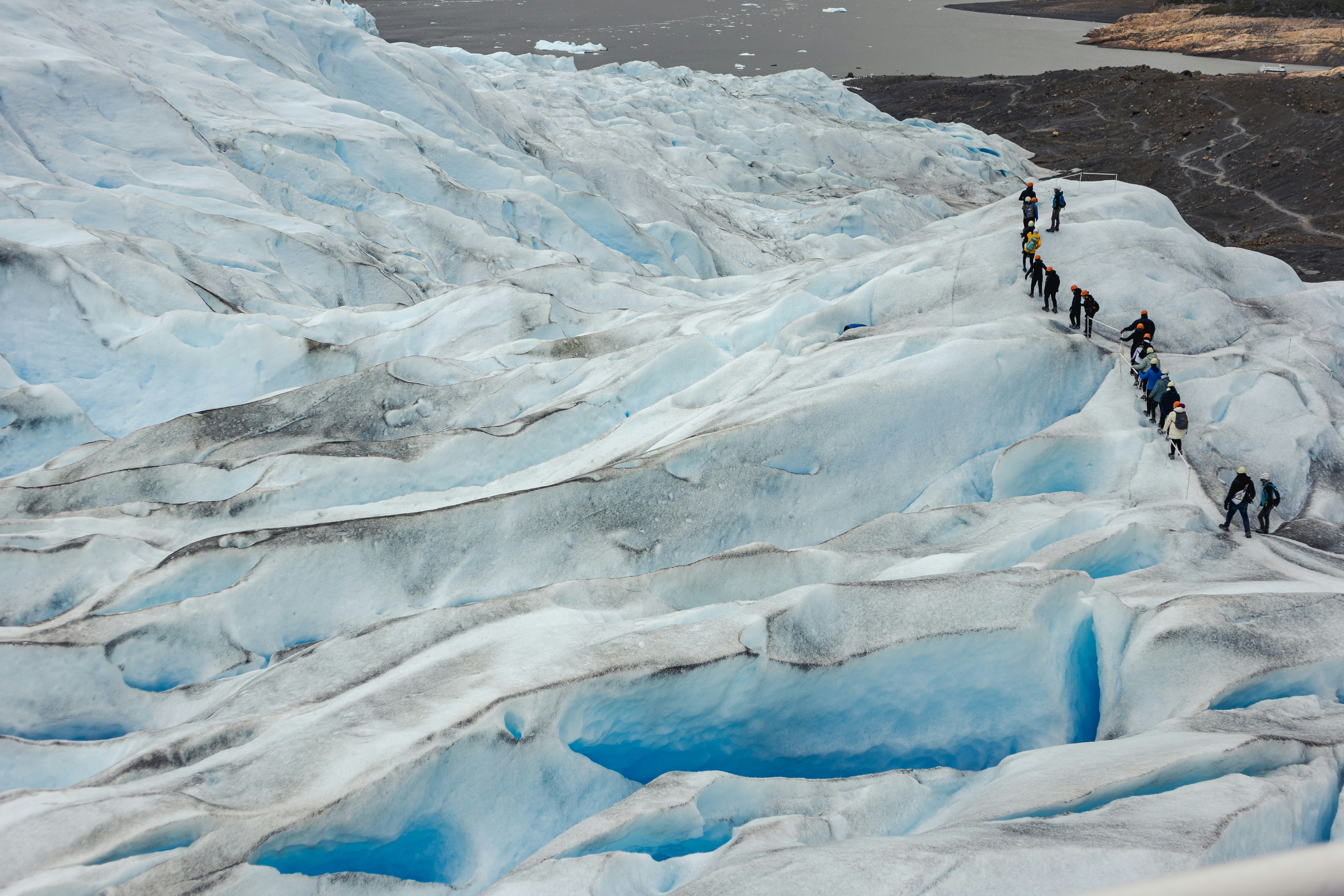 A group of people walking across a bridge made of ice photo – Free ...