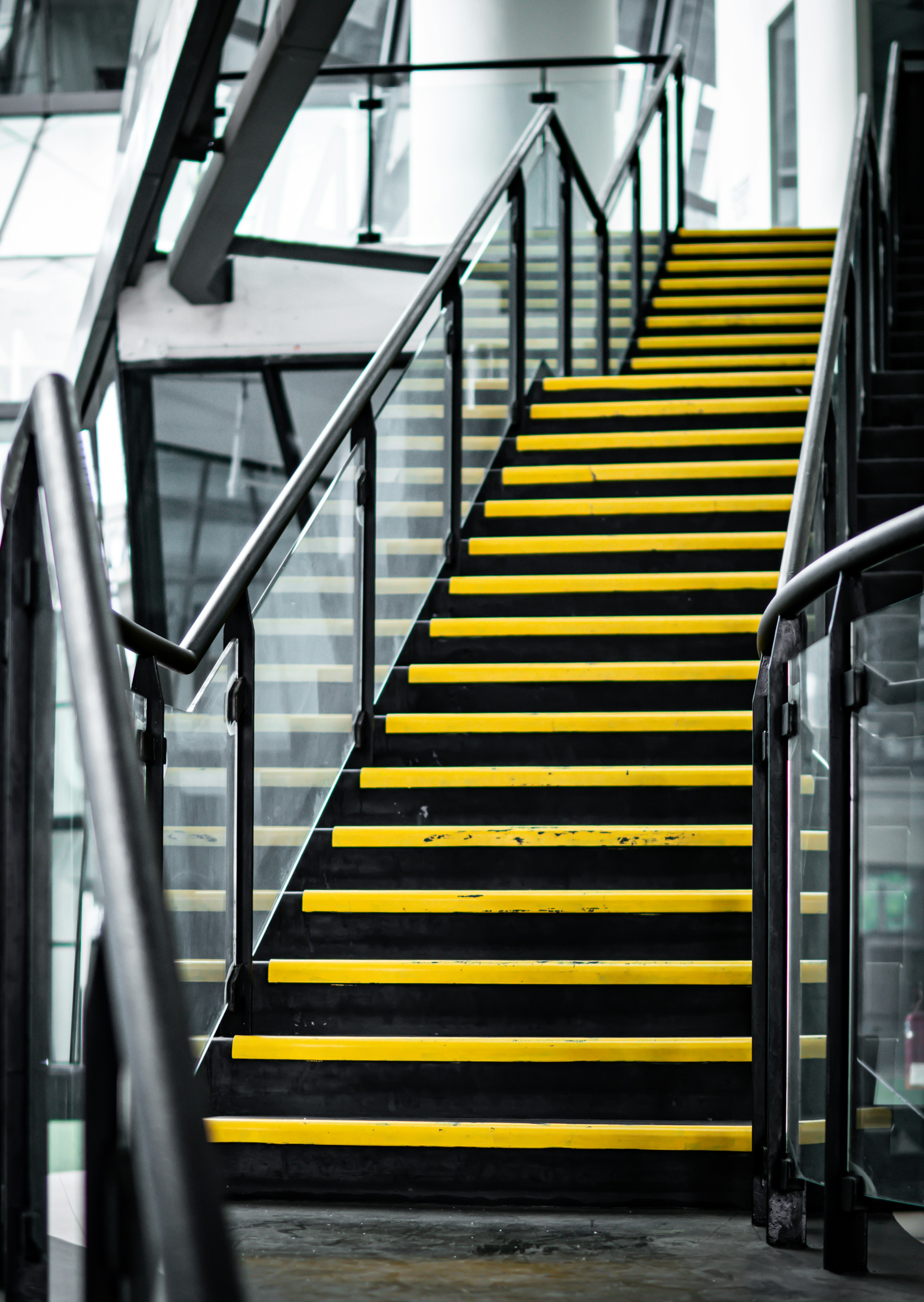 Yellow-Edged Ascent: A Glass-and-Steel Staircase in a Modern Atrium