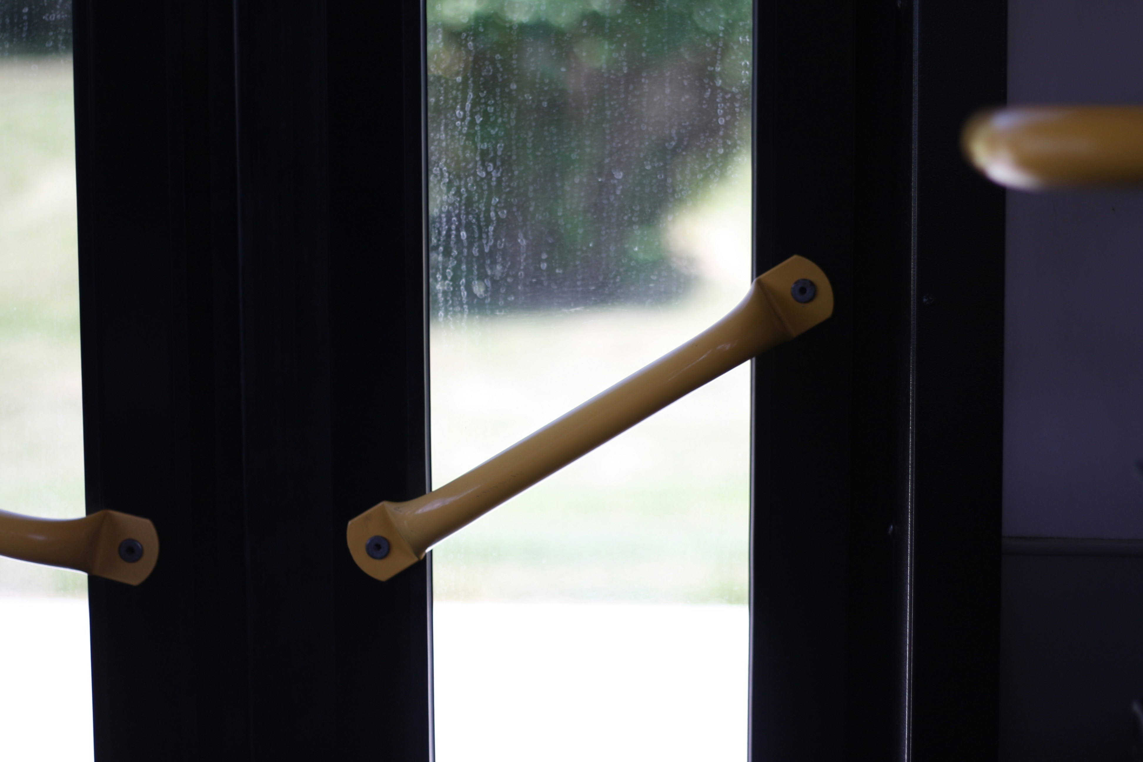 Yellow Bar Handles on a Dark Playground Gate