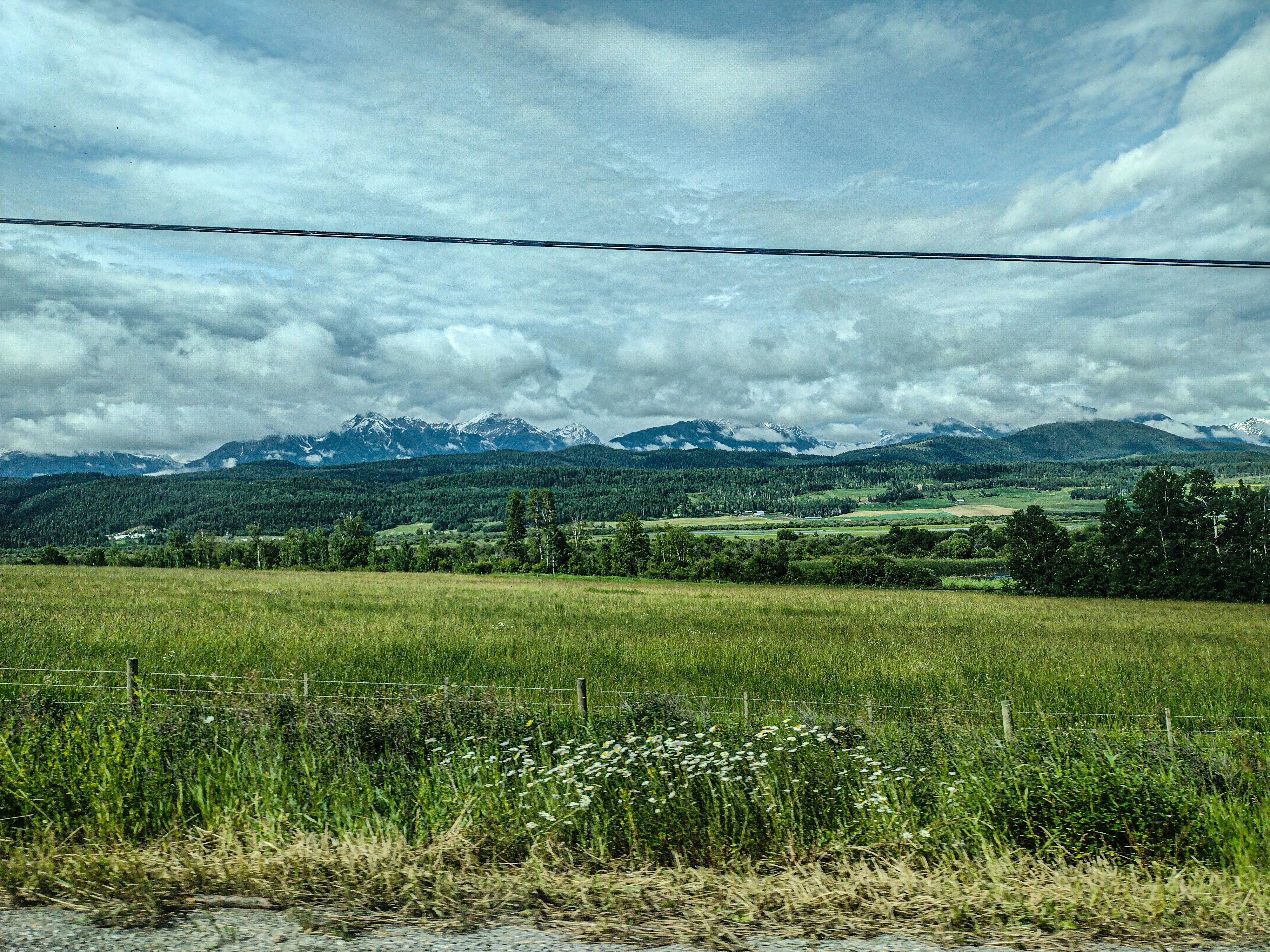 A grassy field with mountains in the distance photo – Free ...