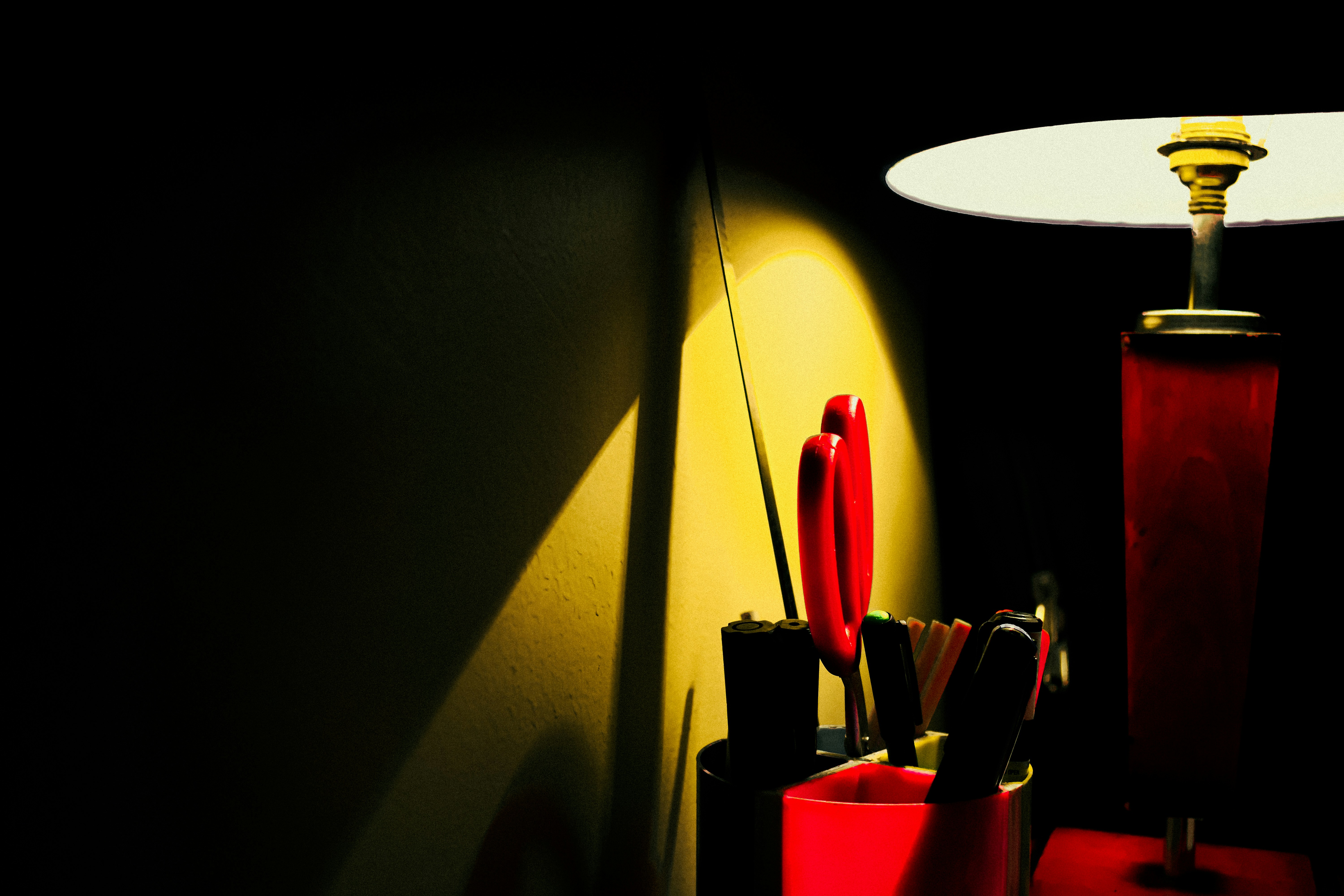 A lamp and some red items in a dark room photo – Free Office Image on ...