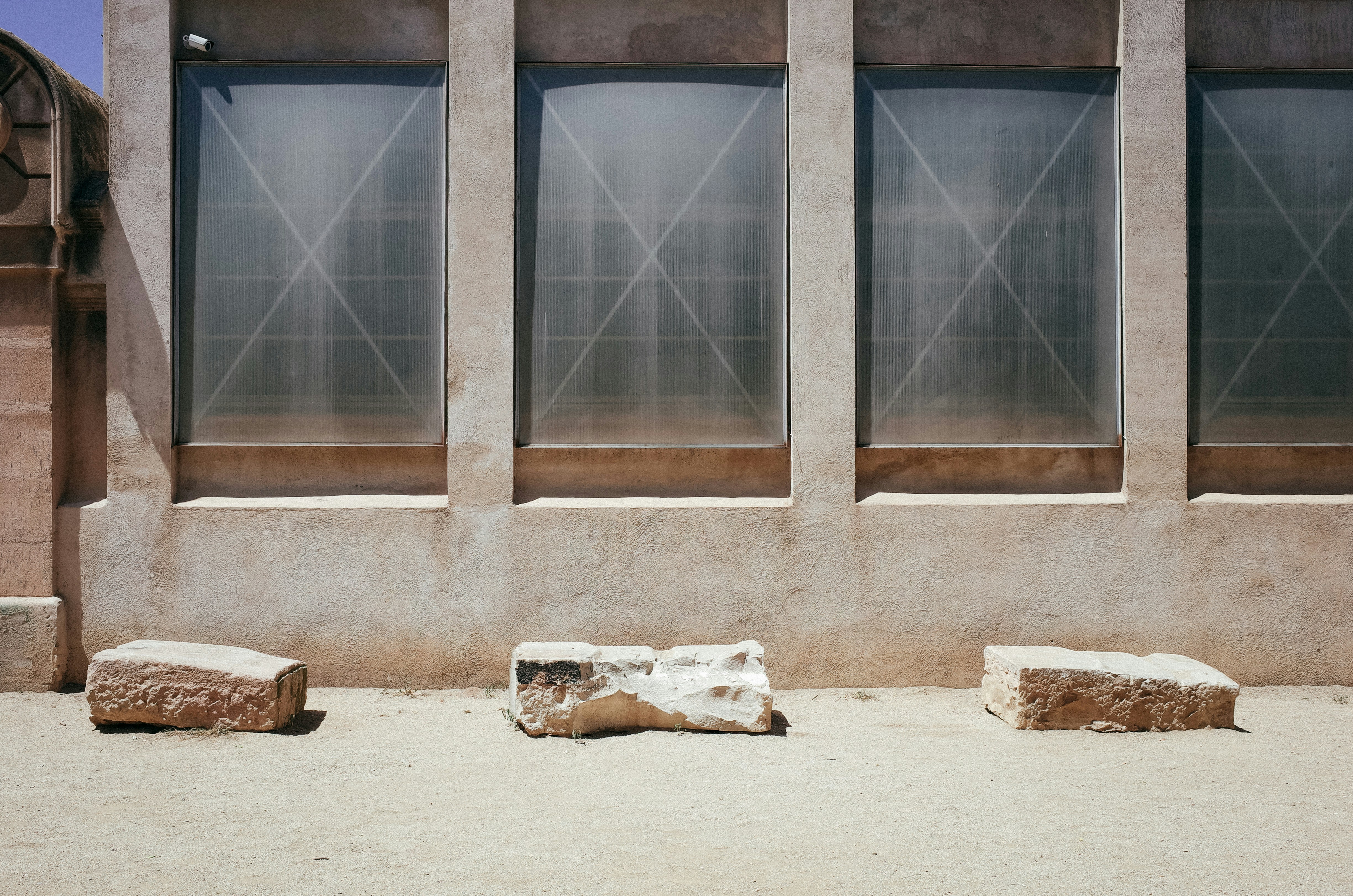 Three Weathered Stones Under a Grid of Frosted Windows