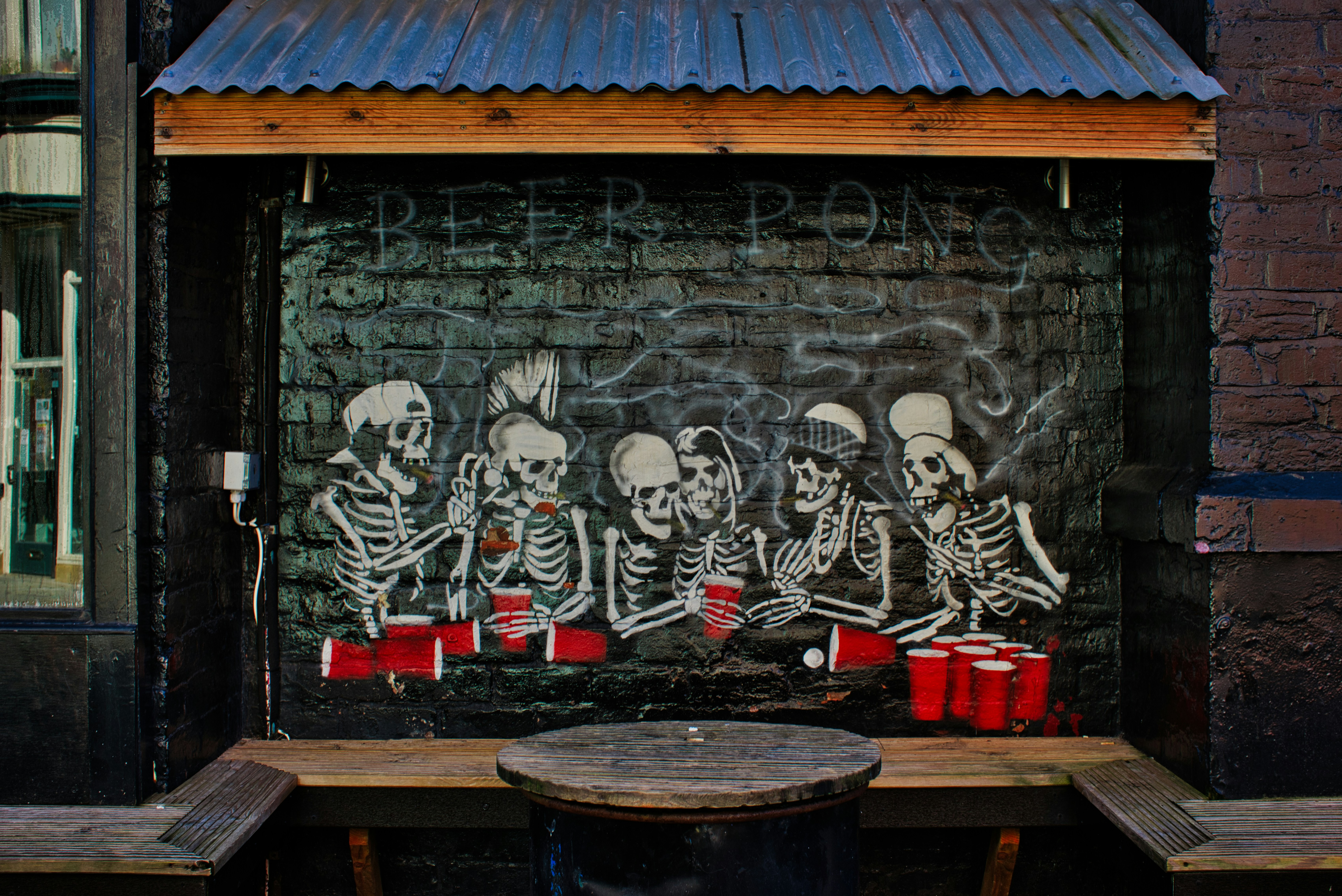Beer Pong Skeletons: A Weathered Chalkboard Mural of Urban Nightlife