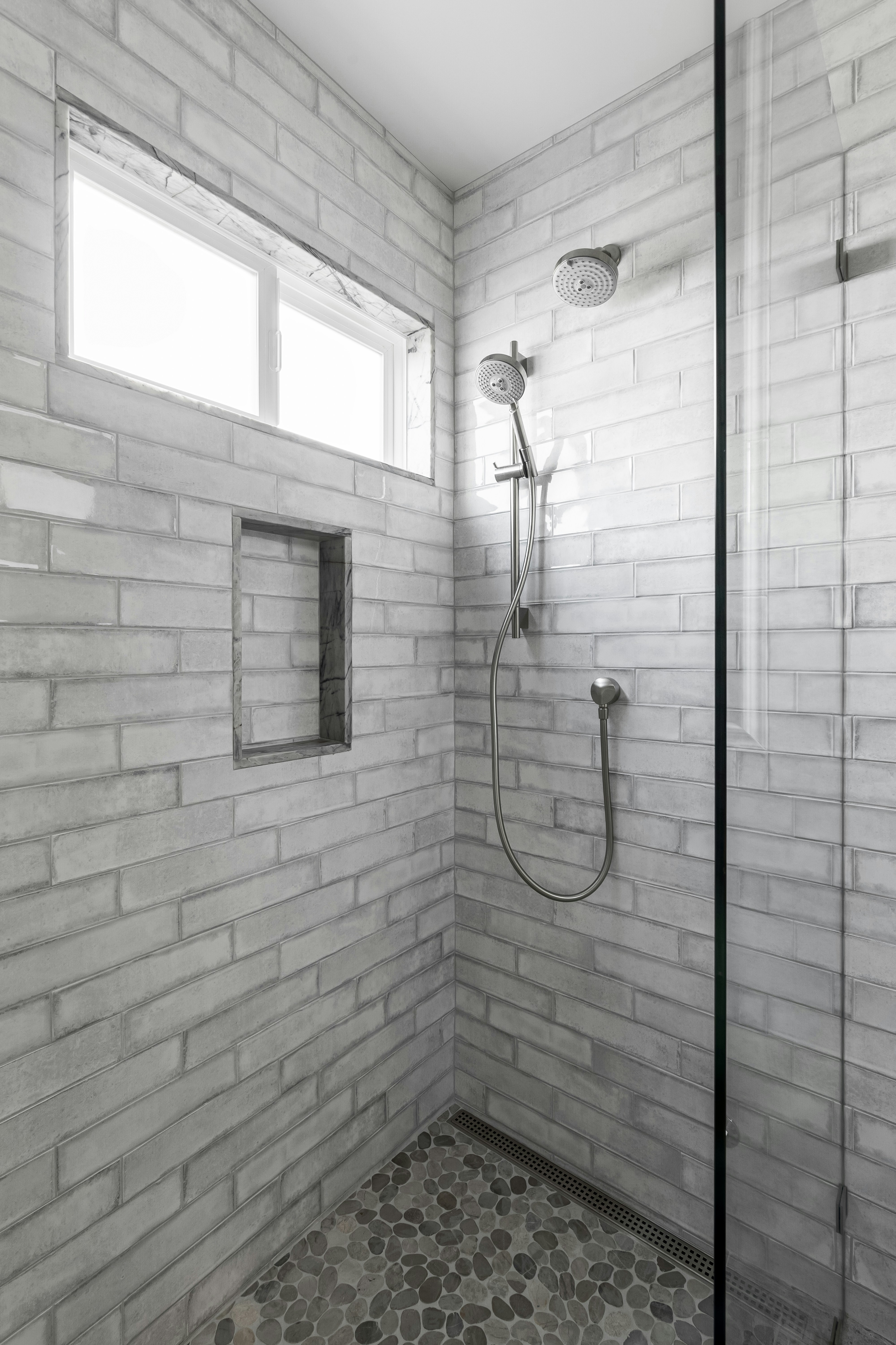 Monochrome Shower Mosaic: Brick Tiles, Niche, and Pebble Floor