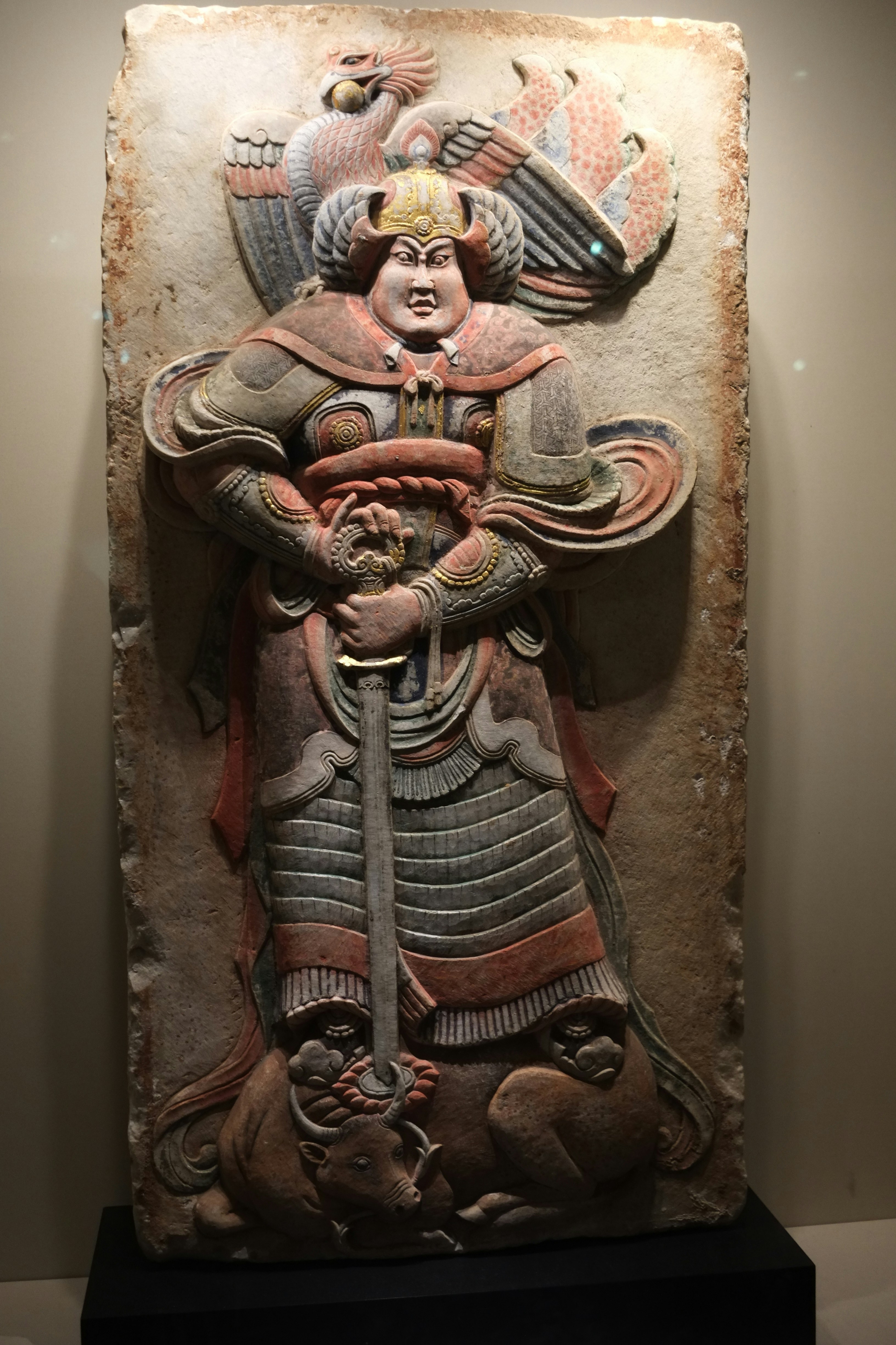 Ram-Horned Warlord in Bas-Relief: Sword-Bearing Guardian under a Winged Crest