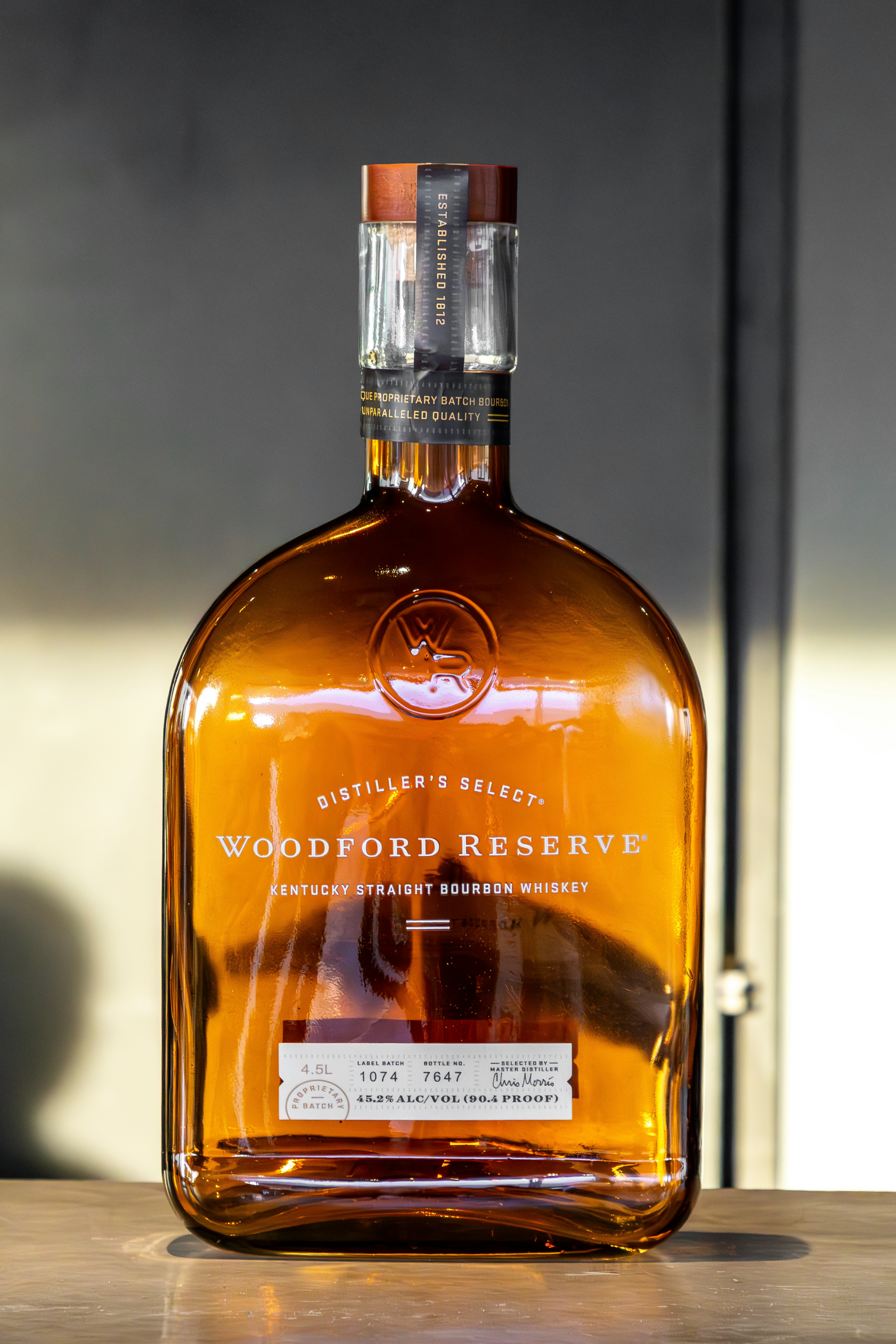 Woodford Reserve bourbon bottle showcasing its distinctive shape and rich amber color against a softly blurred background.