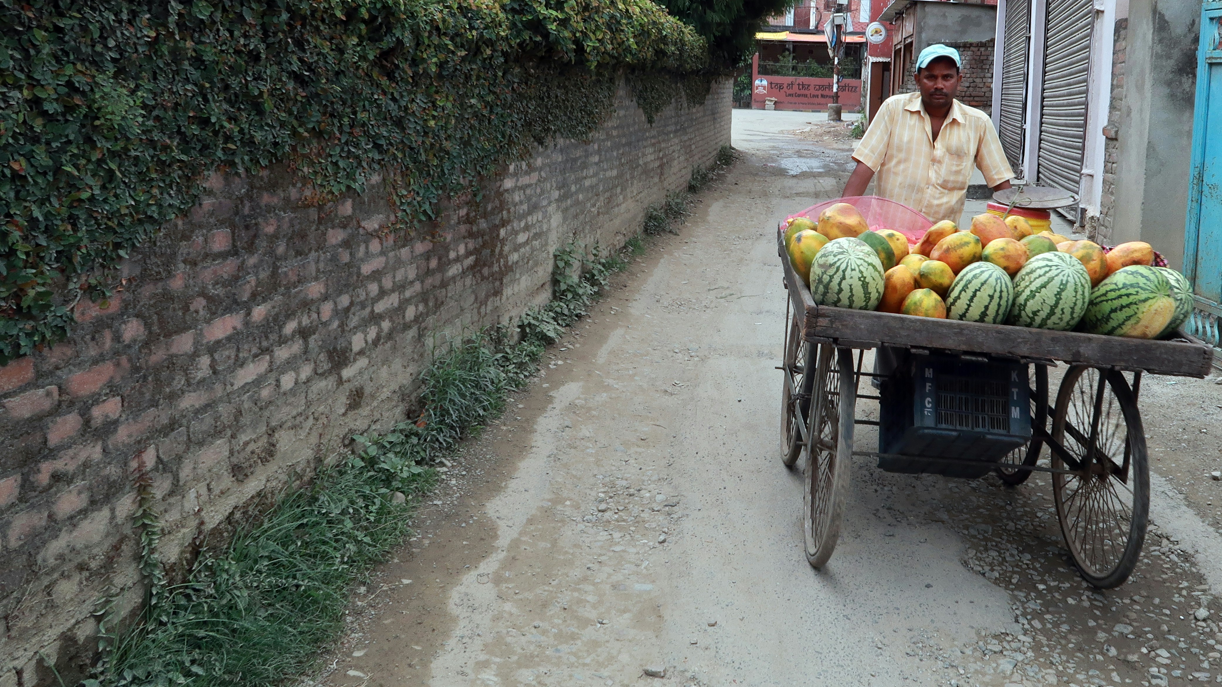 Fruit cart on a sunlit alleyway in a quiet neighborhood