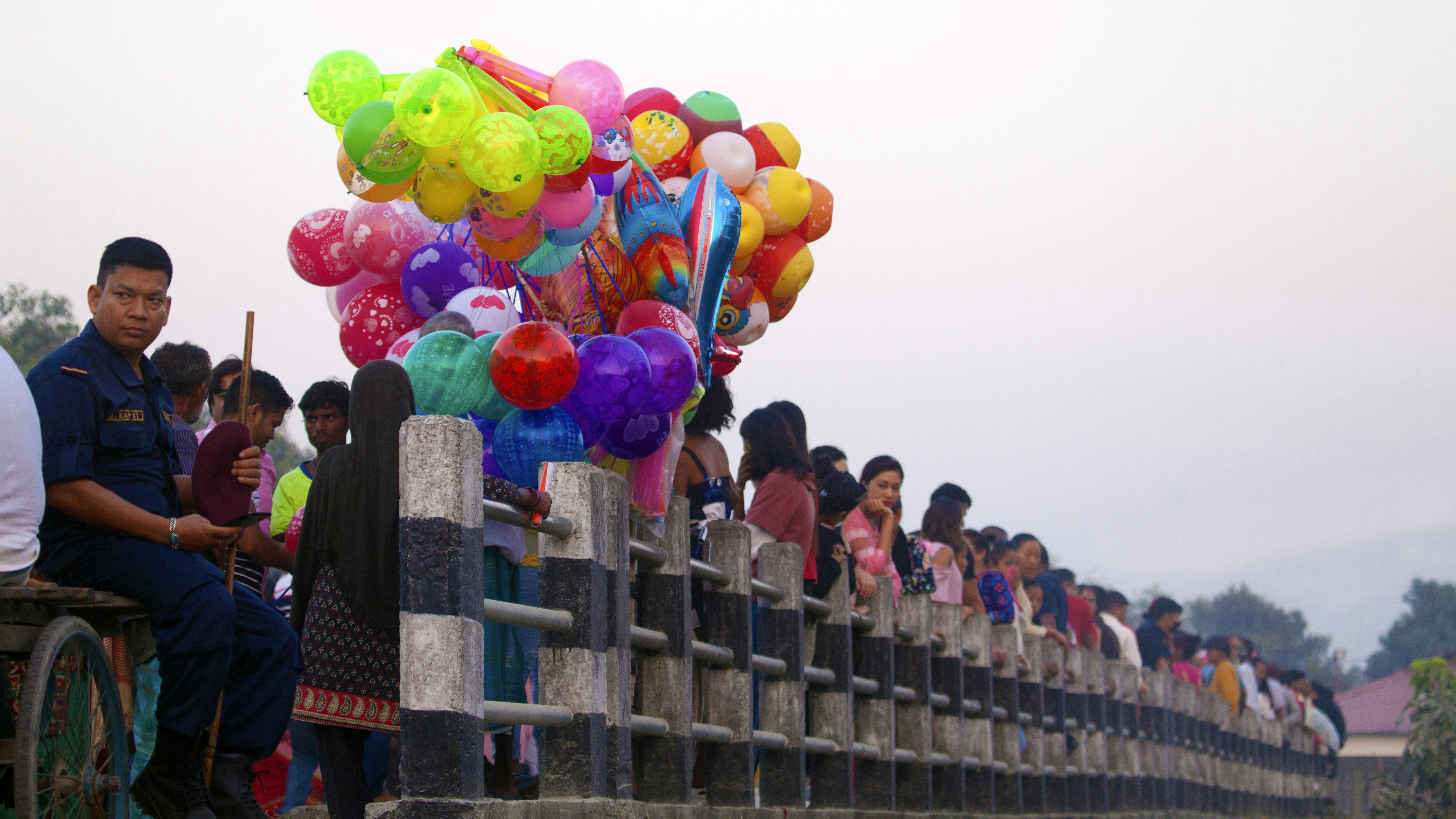 Balloon Parade Over a Riverside Fence