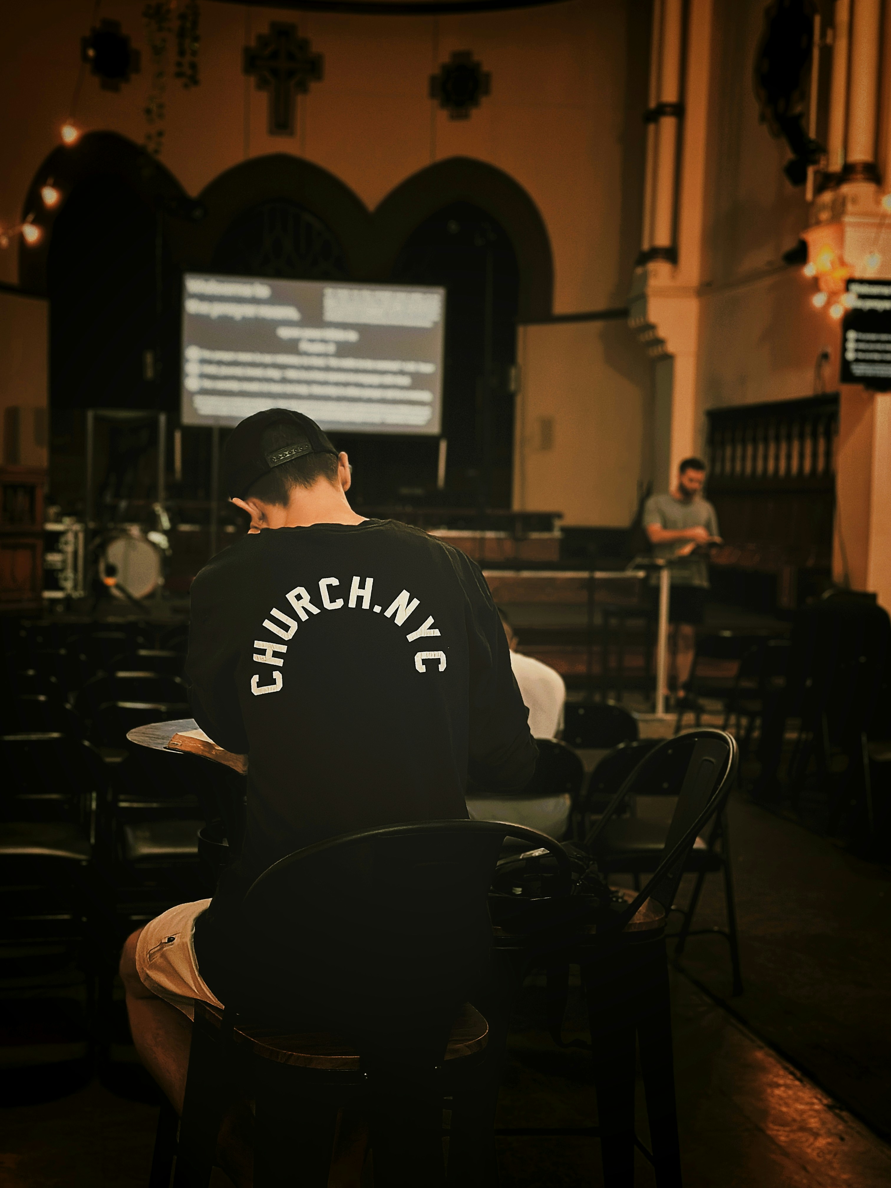 Backstage Glow: A Lone Crew Member in a Warm Church Hall Before Rehearsal