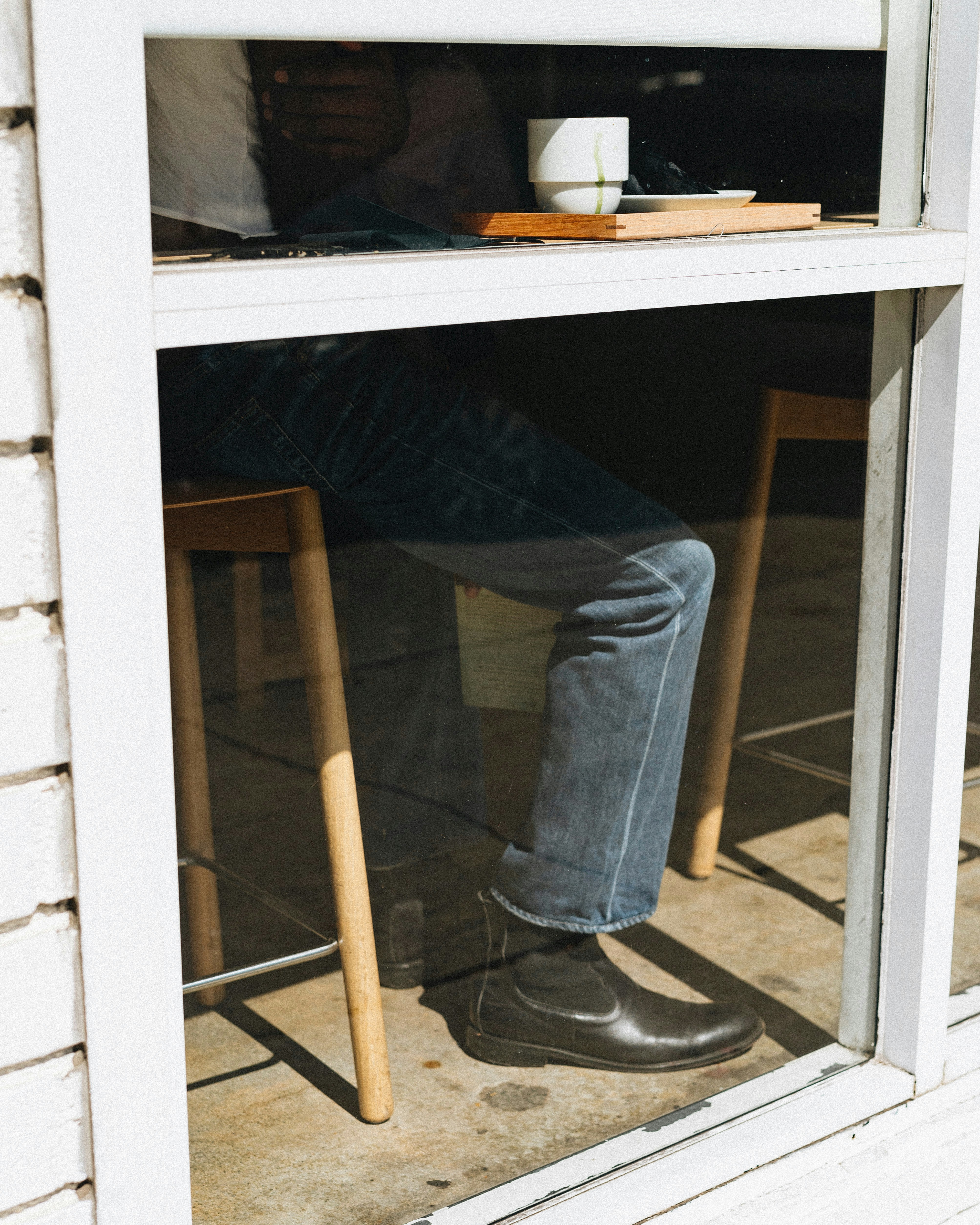 A man sitting in a window sill with his feet propped up photo – Free ...