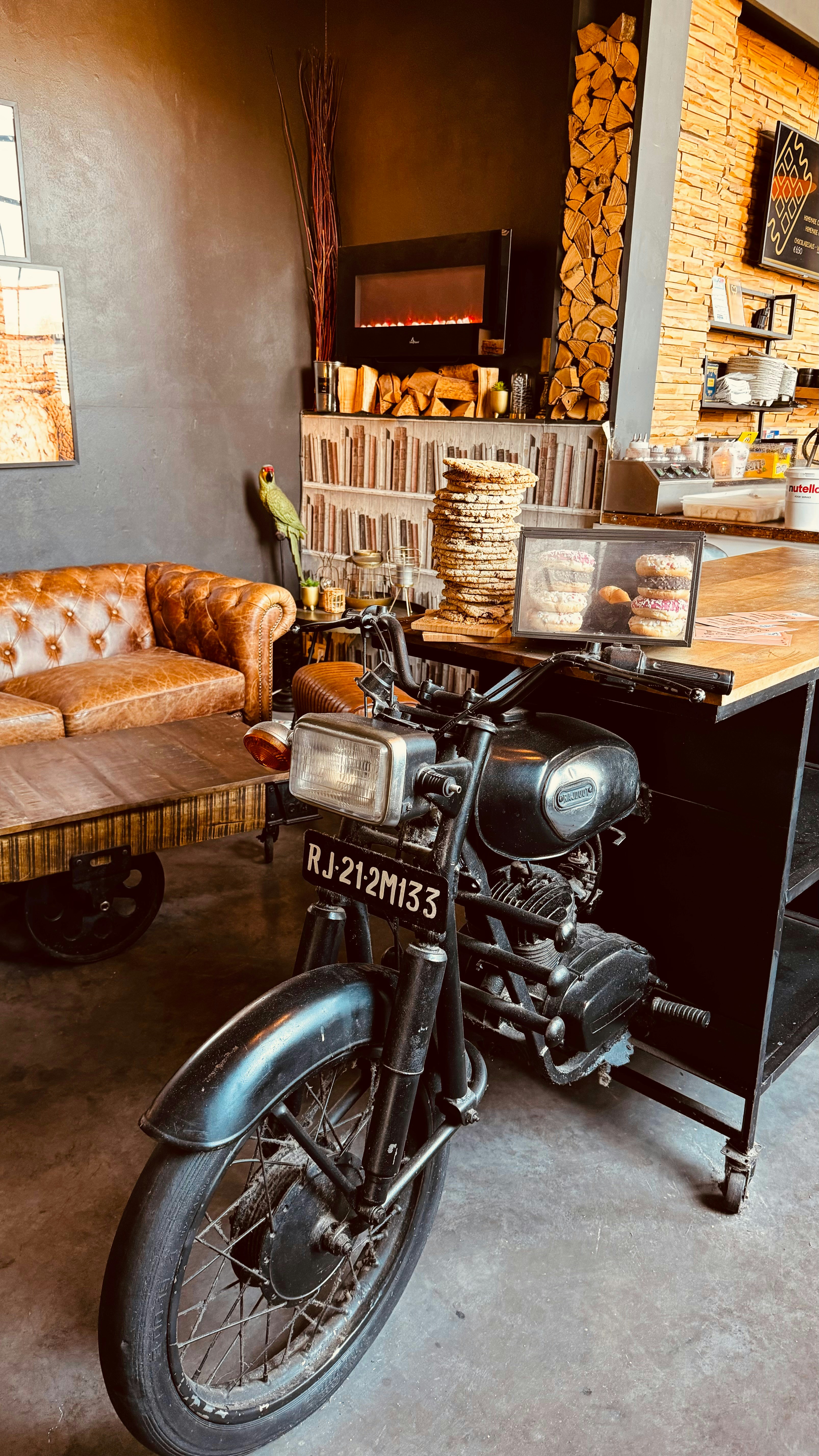 A motorcycle parked next to a couch in a room photo – Free Belçika ...