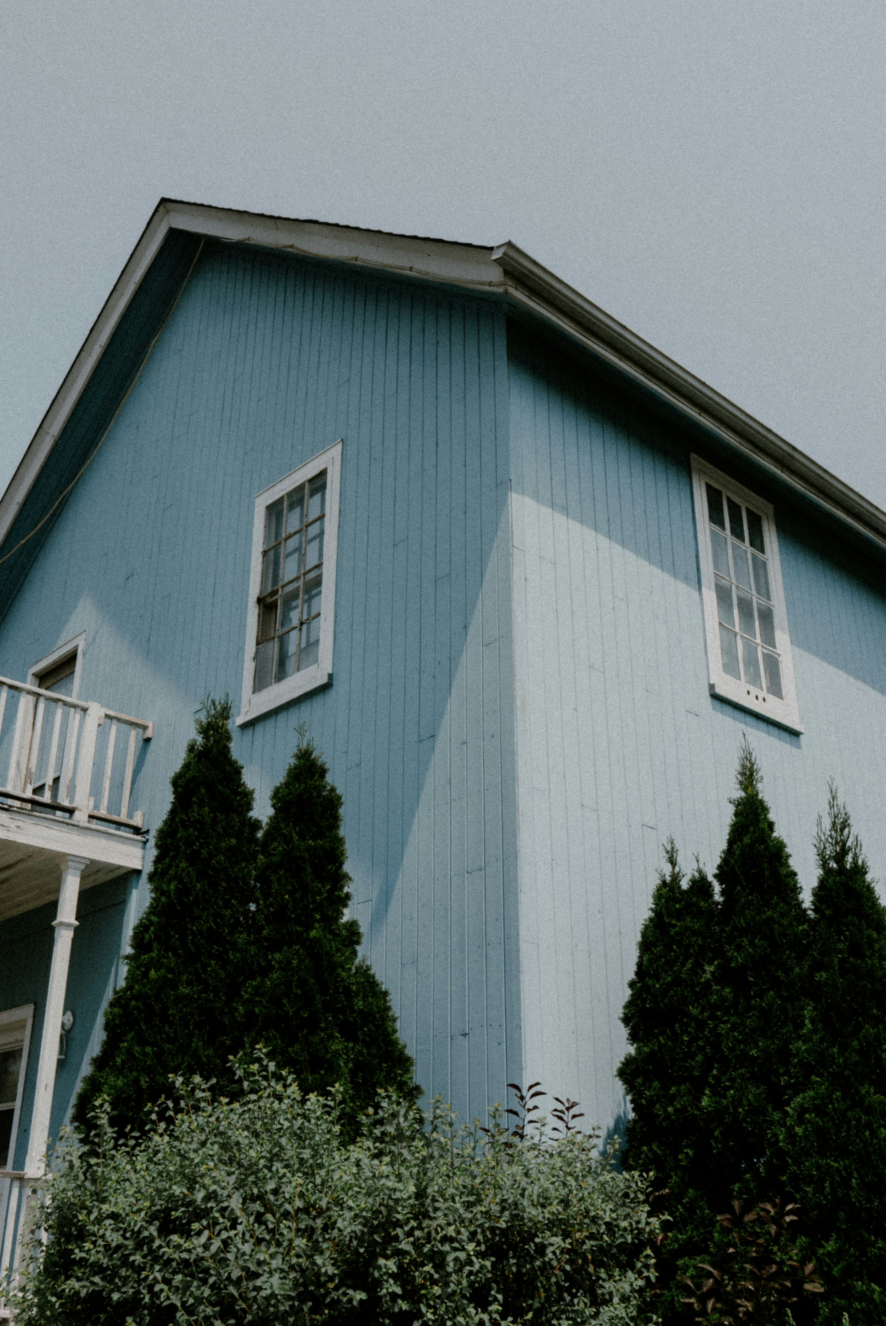 A blue house with a balcony and trees photo – Free Unionville Image on ...