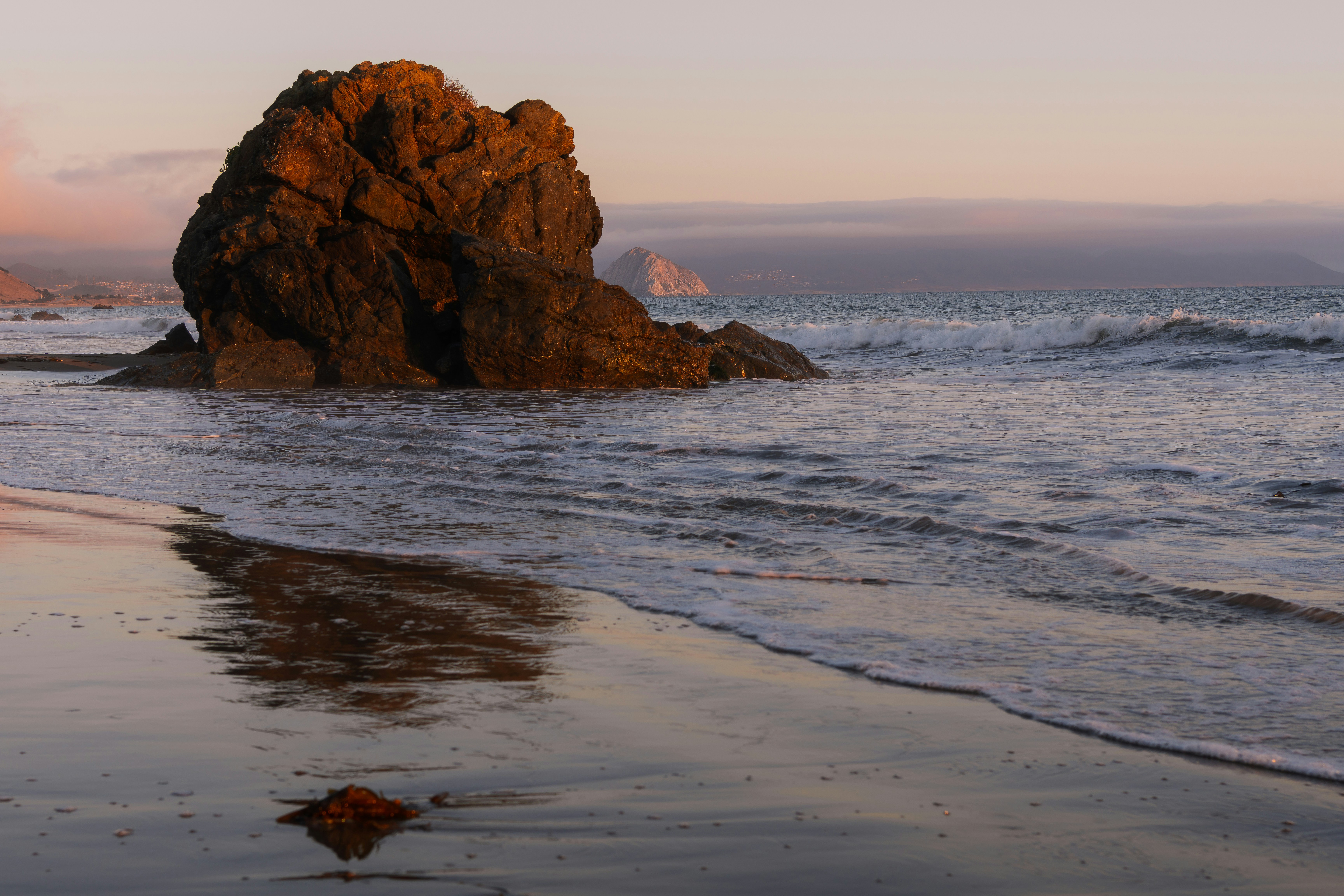 Un rocher qui sort de l’eau sur la plage photo – Image gratuite de ...