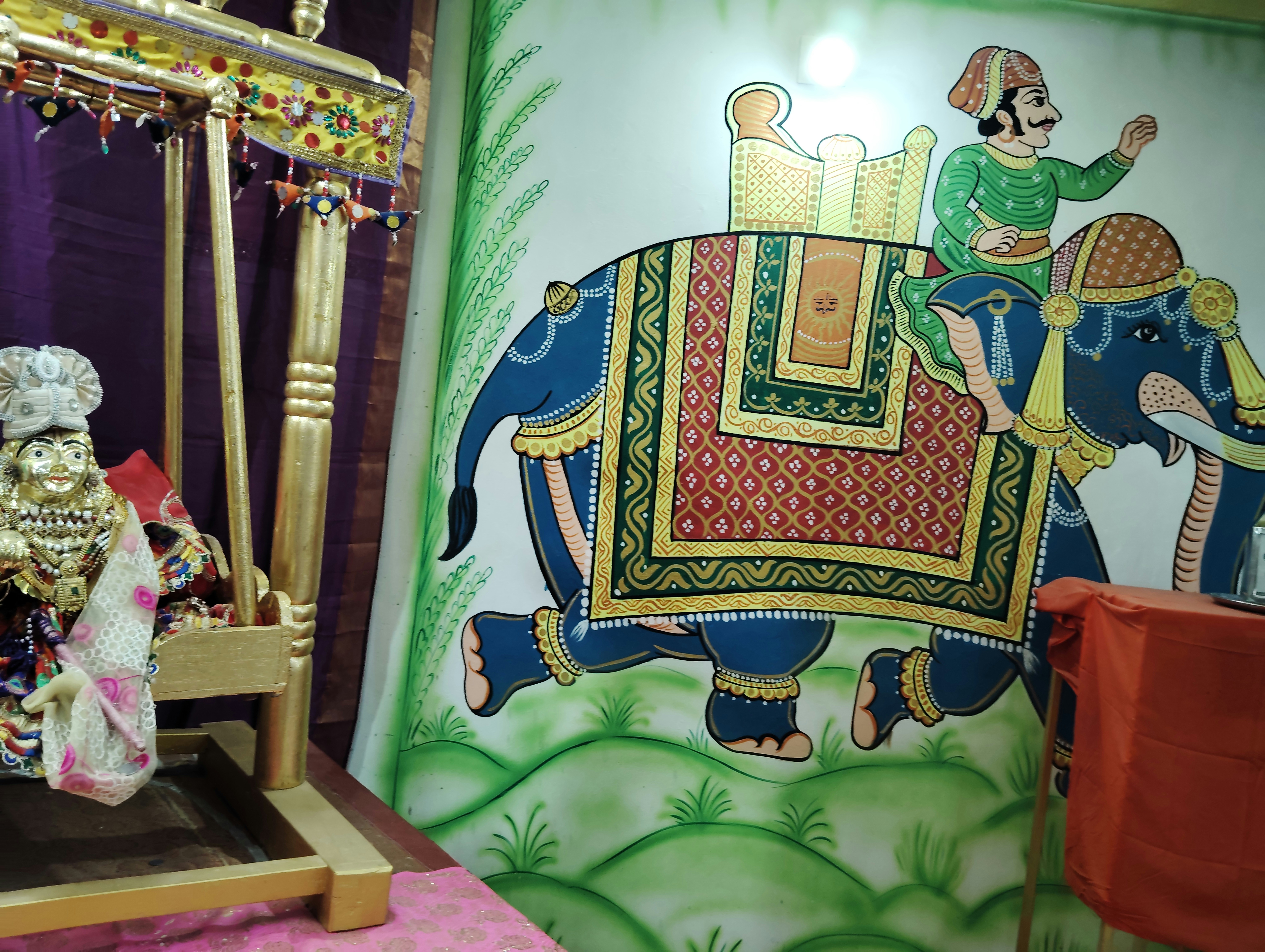 A decorated wall with a painting of a man riding an elephant photo ...