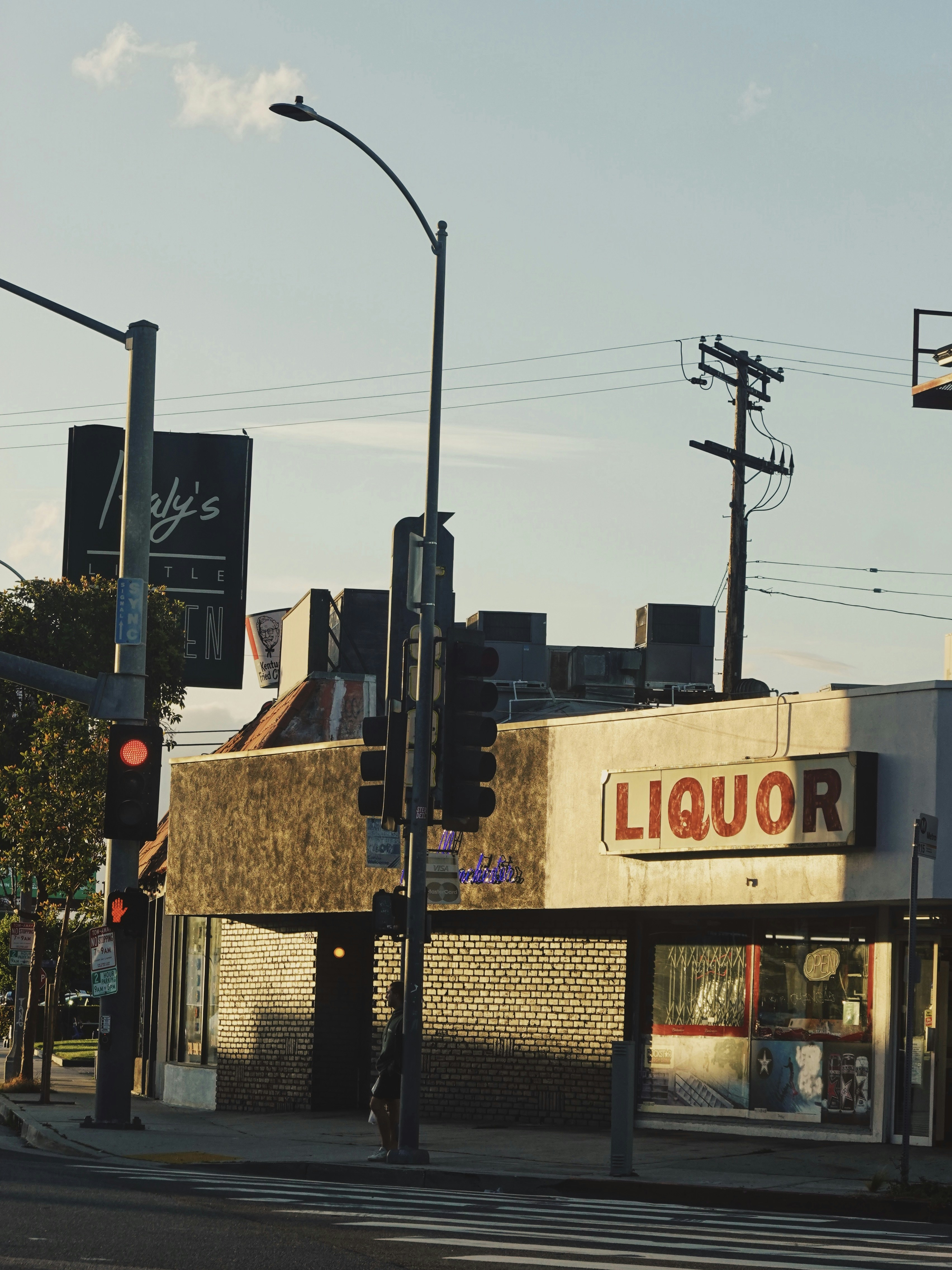 Sunlit Corner Liquor Store Amid Urban Signals