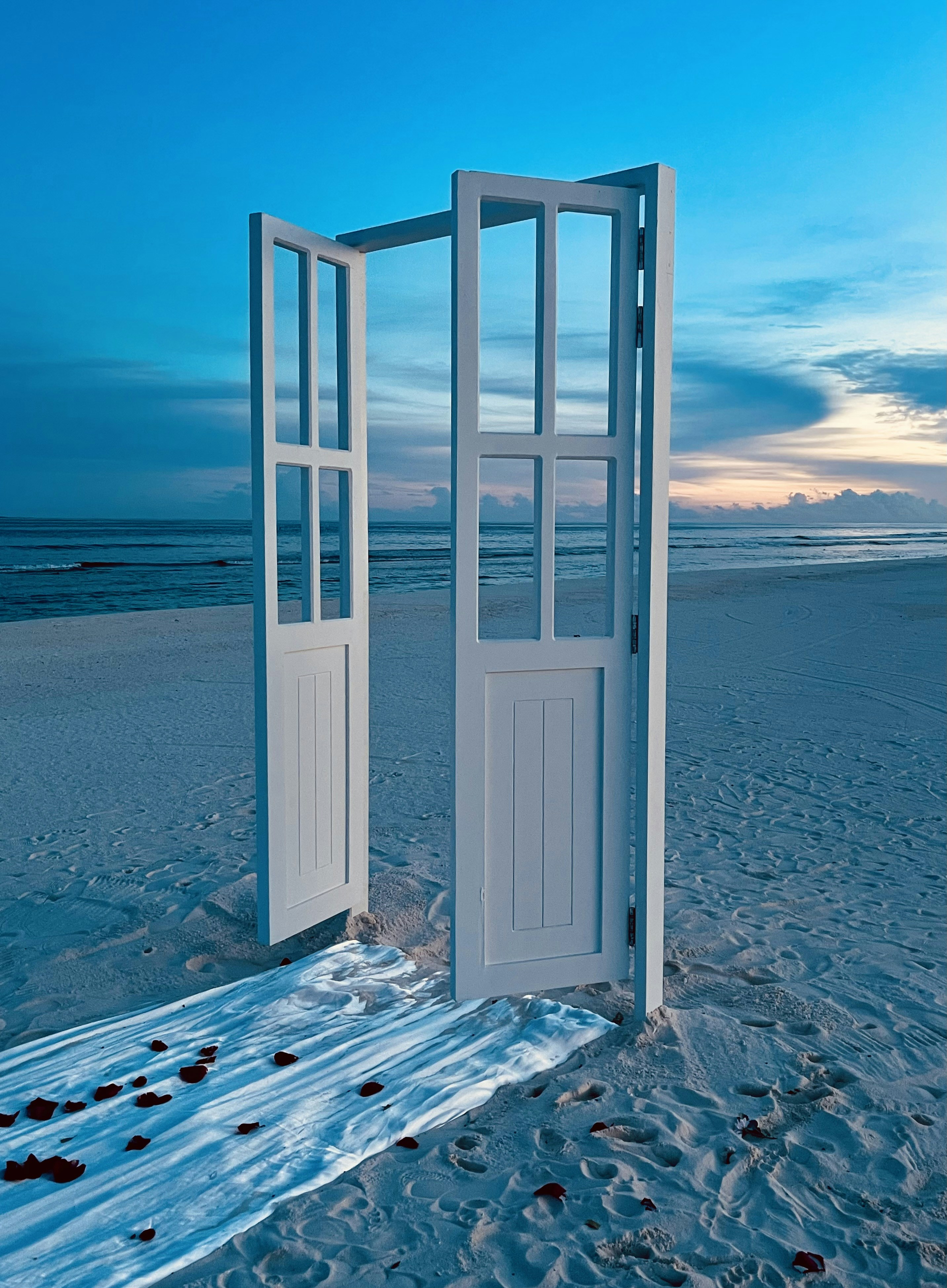 The Seaside Portal: White Doors Framed by Dune and Dusk