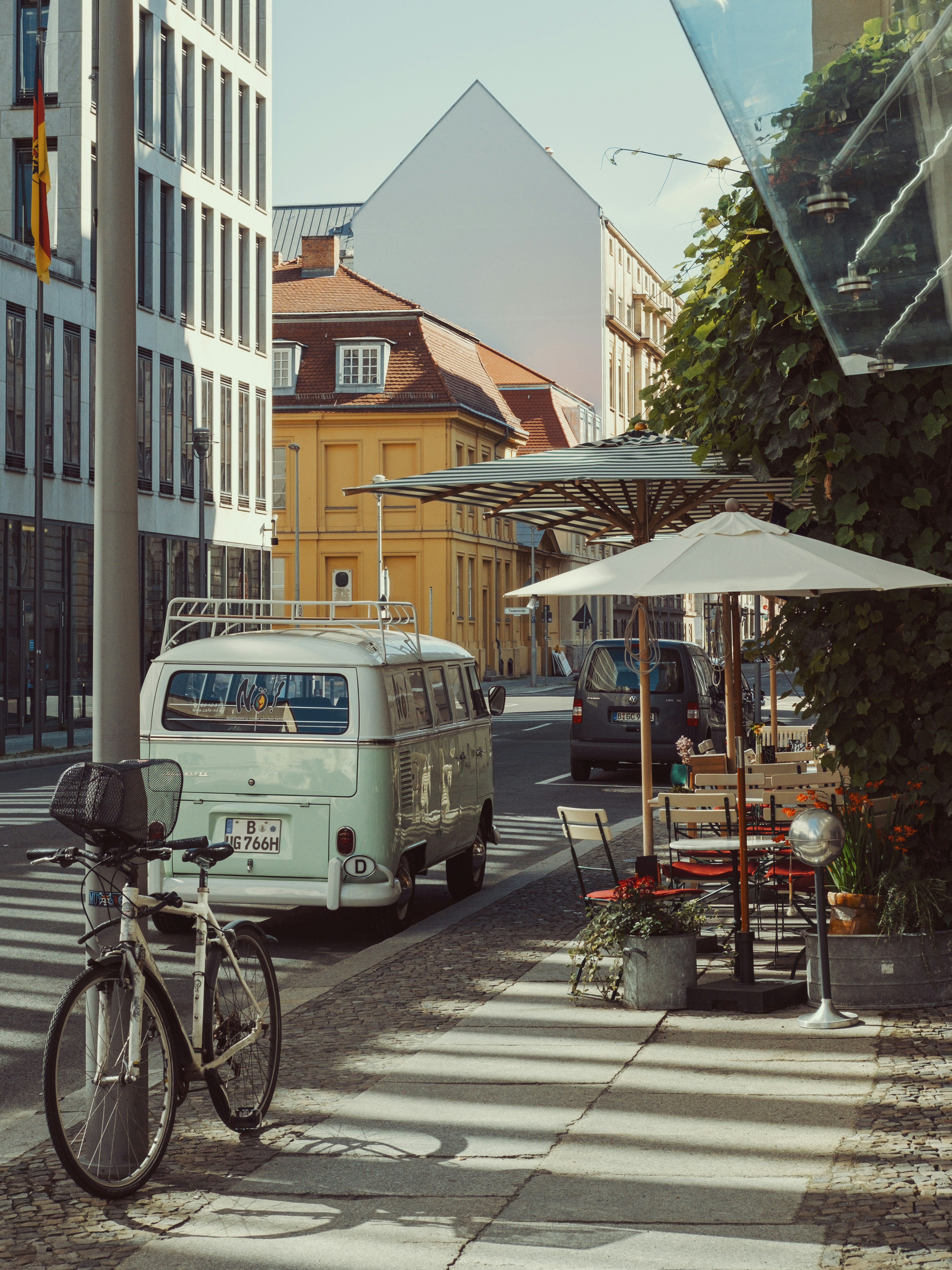 Mint VW Bus Under Dappled Light on a Quiet European Street
