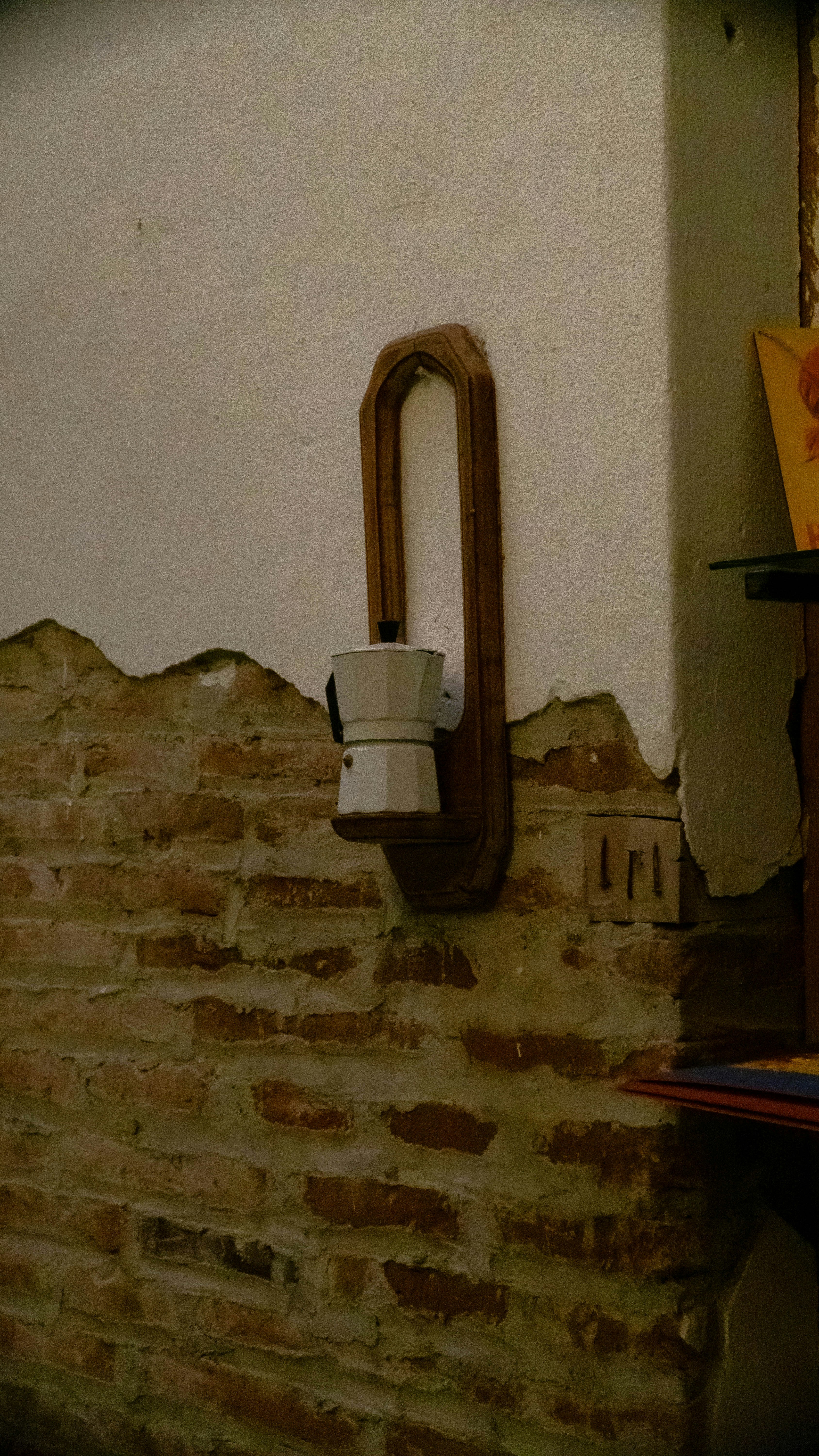 A bathroom with a toilet and a brick wall