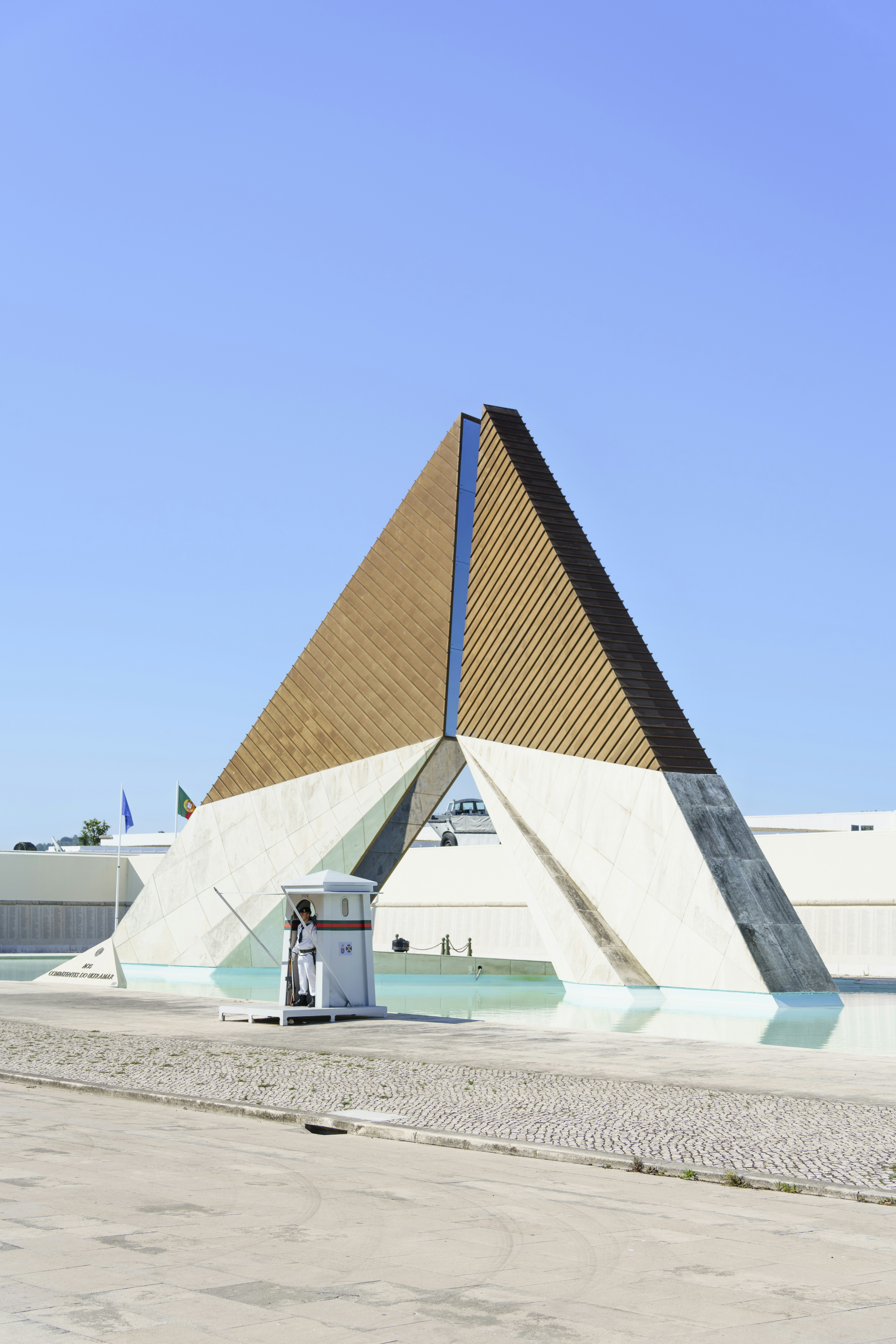 Apex under Cerulean Sky: The Pyramid Monument Rising from a Reflective Plaza