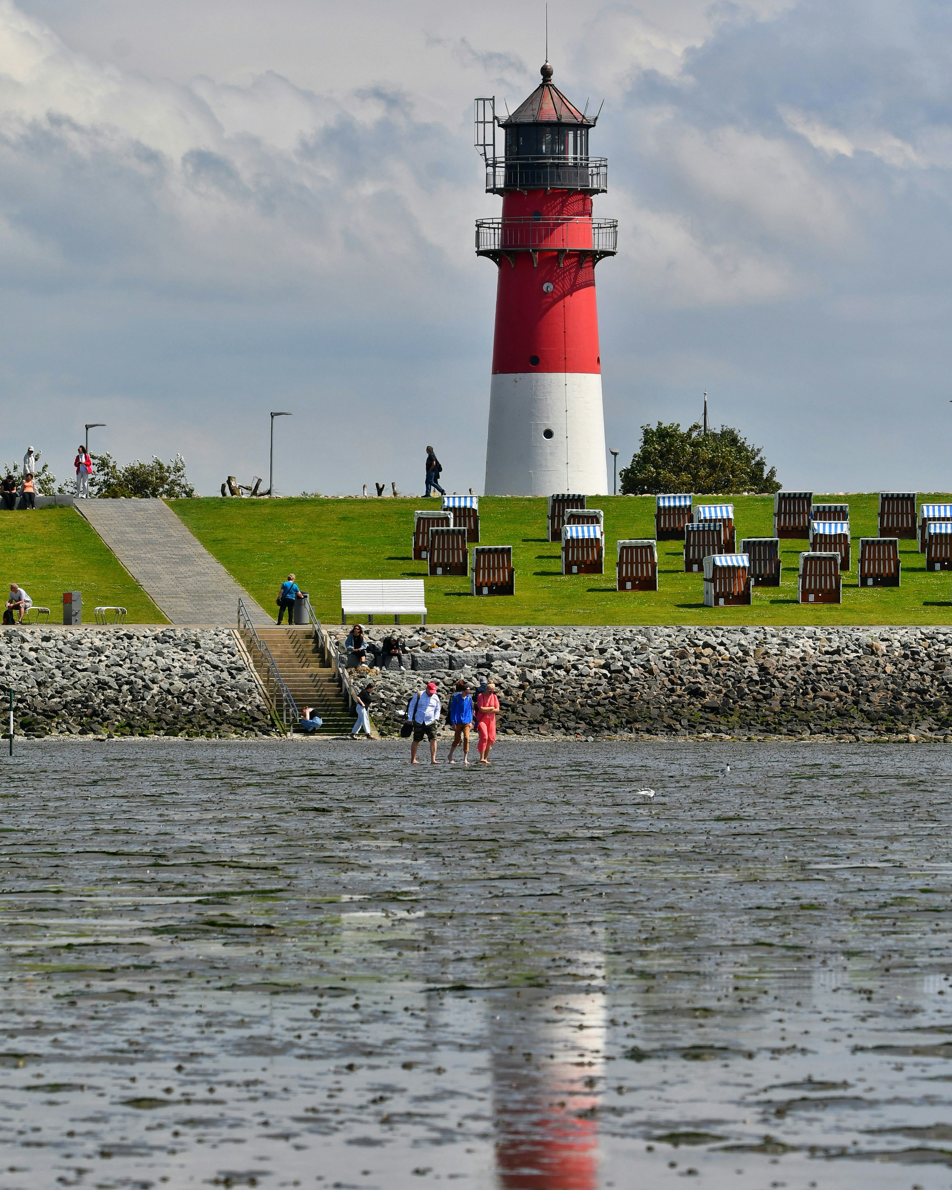 A red and white light house next to a body of water photo – Free Büsum ...