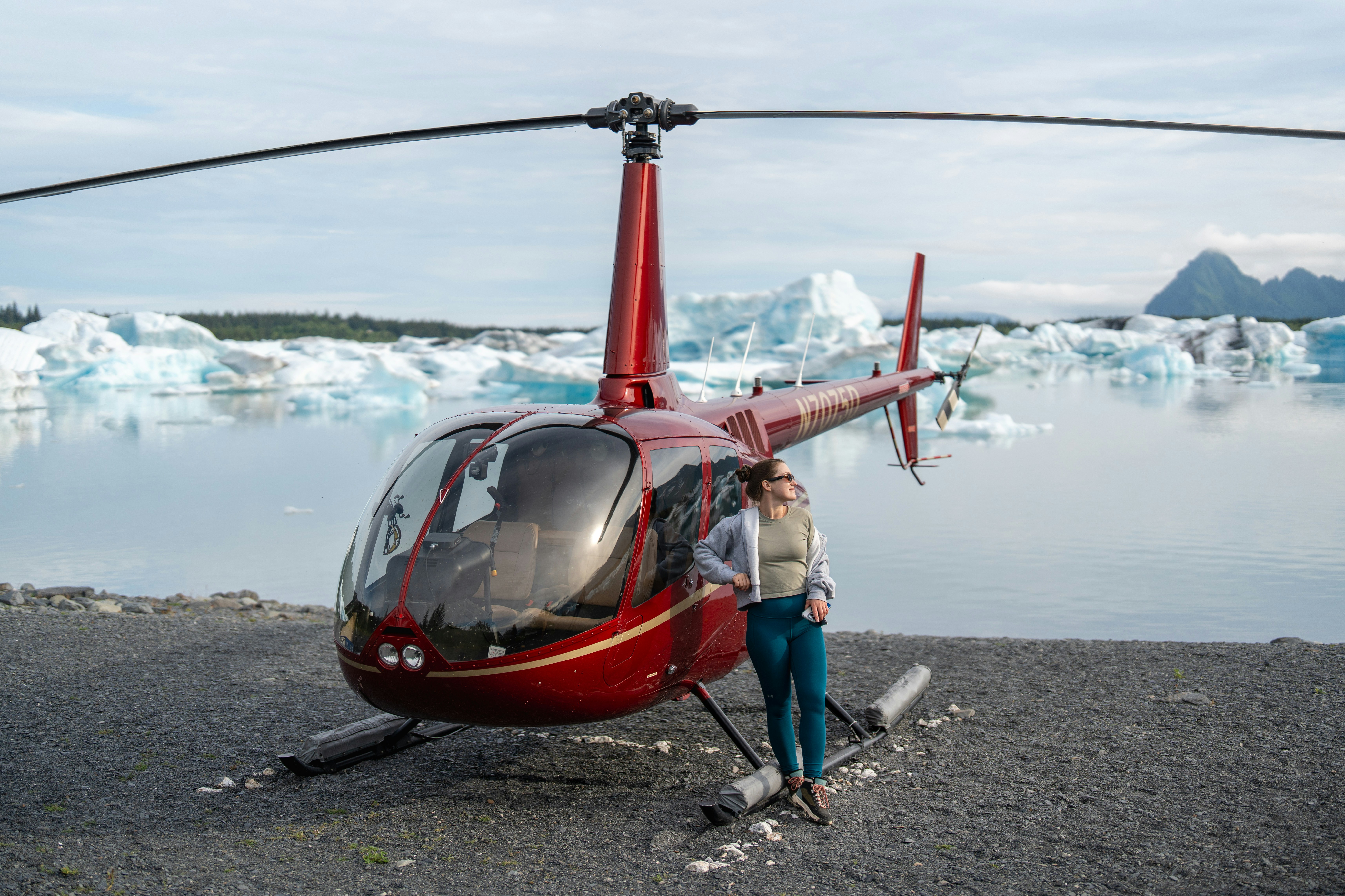 Crimson Helicopter at the Ice-Shore: A Lone Traveler and Glacial Backdrop
